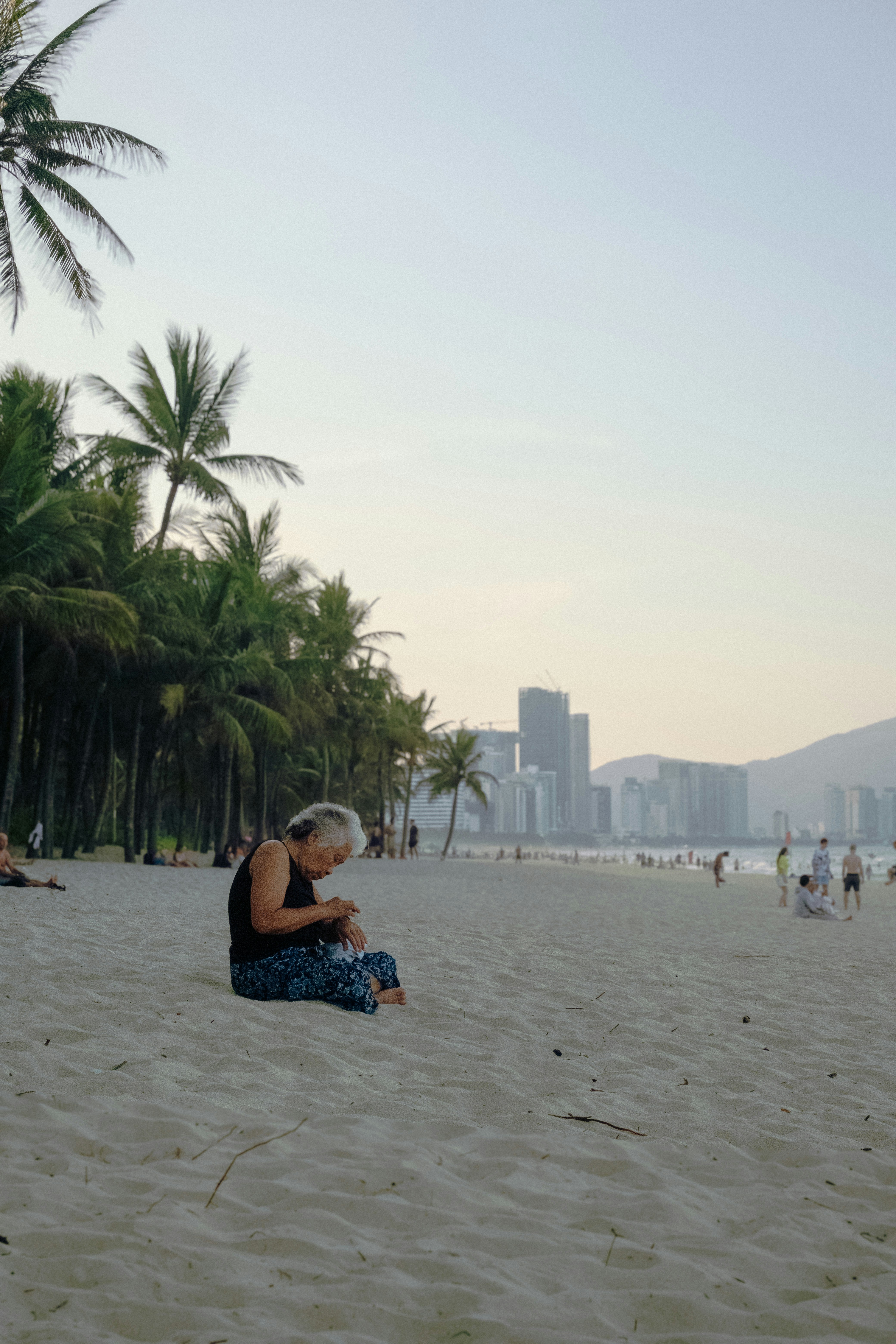 Solitary Moment: Elderly Photographer on the Sunset Beach