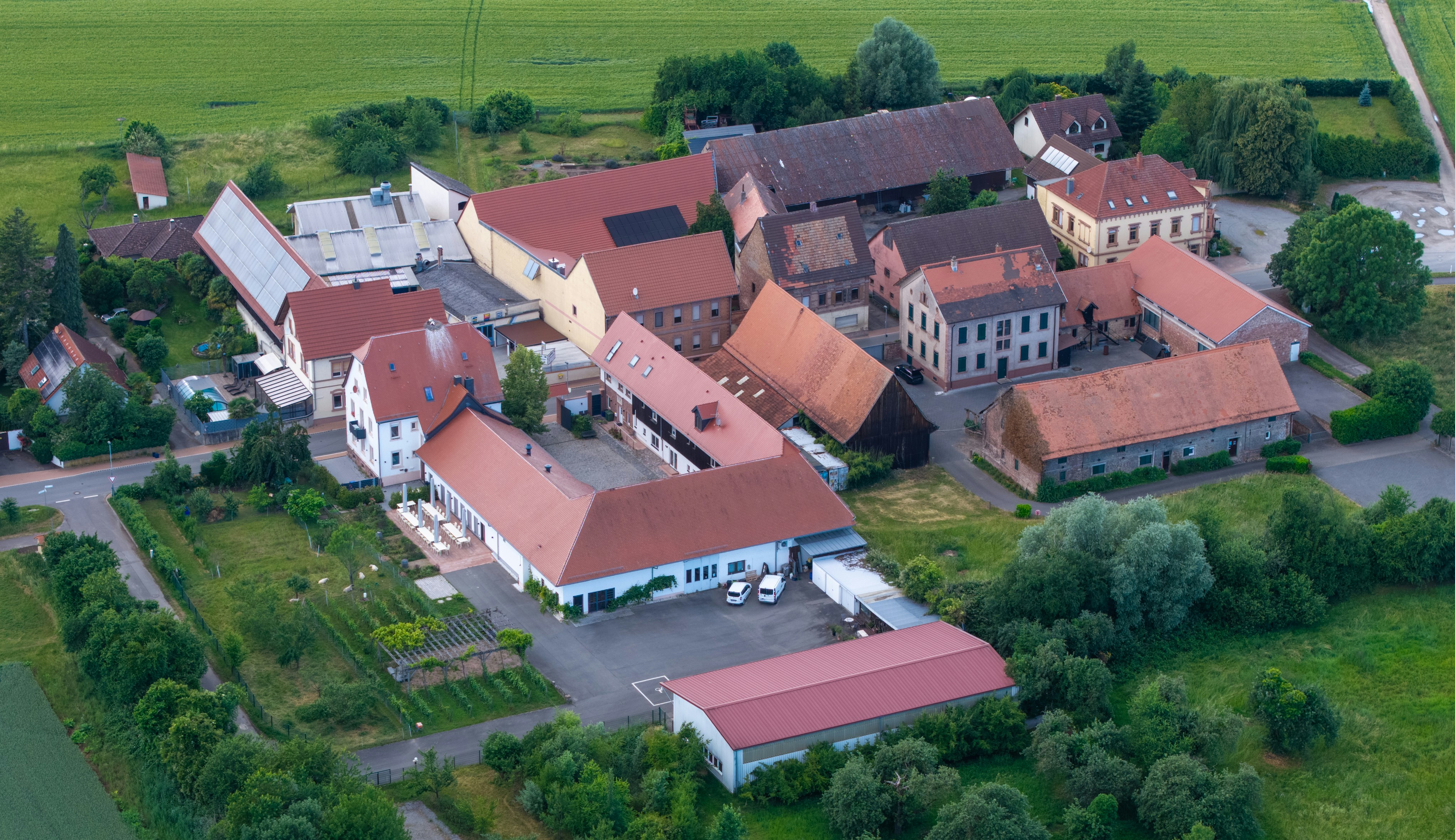 Aerial view of farm buildings surrounded by green fields.