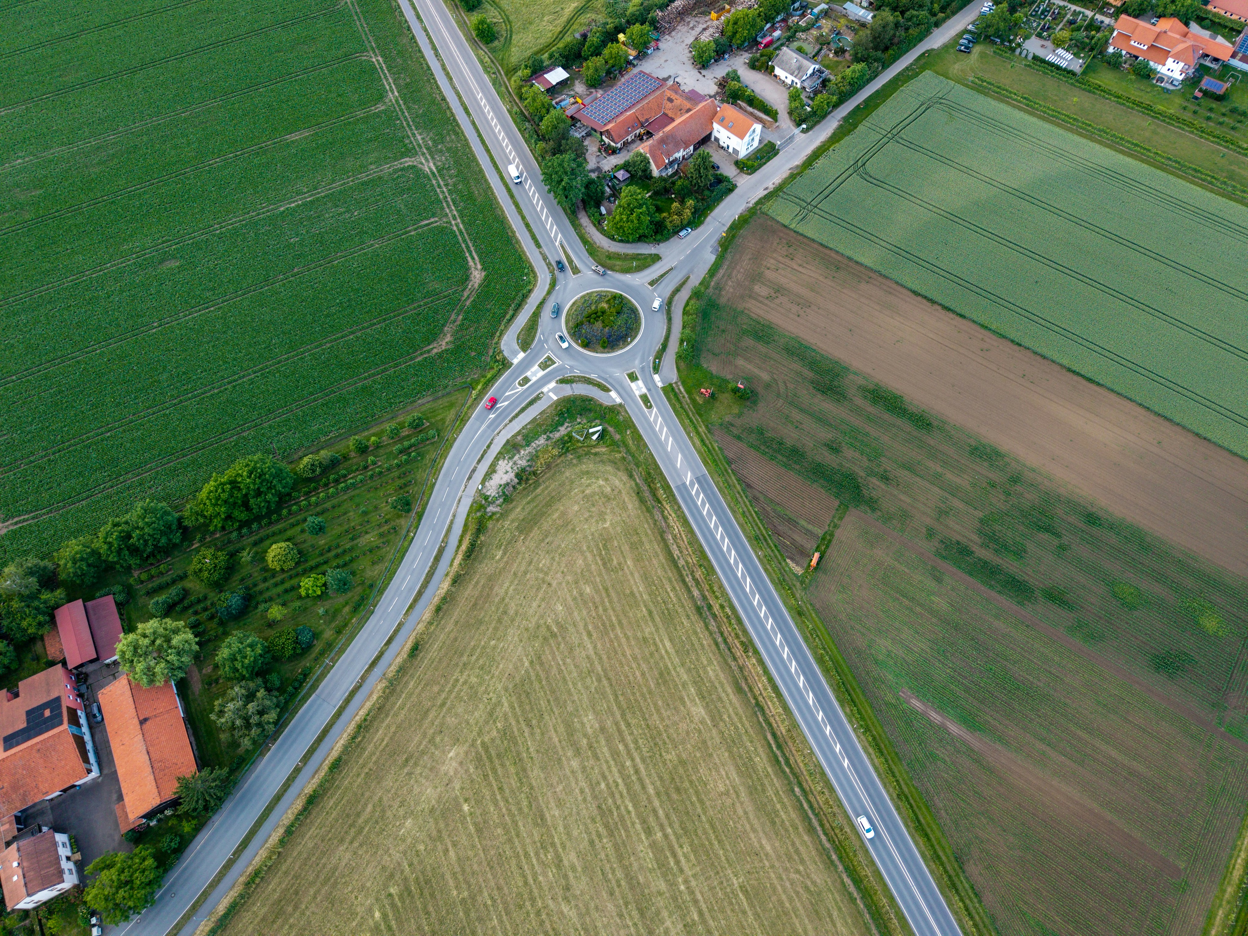 Aerial view of a rural roundabout connecting roads and fields.