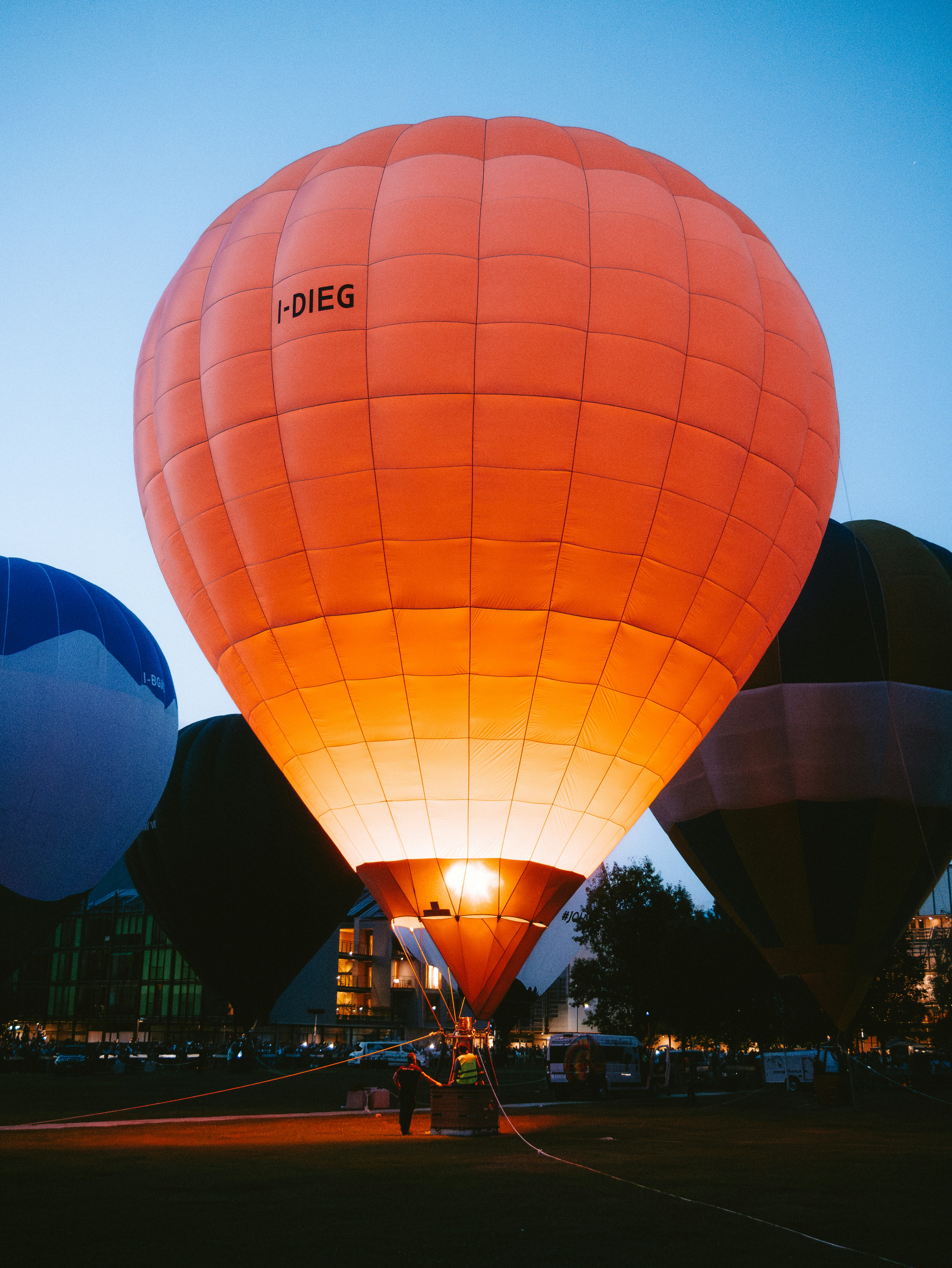 Balloon Inferno: A Ground Crew Under a Creamy Orange Giant