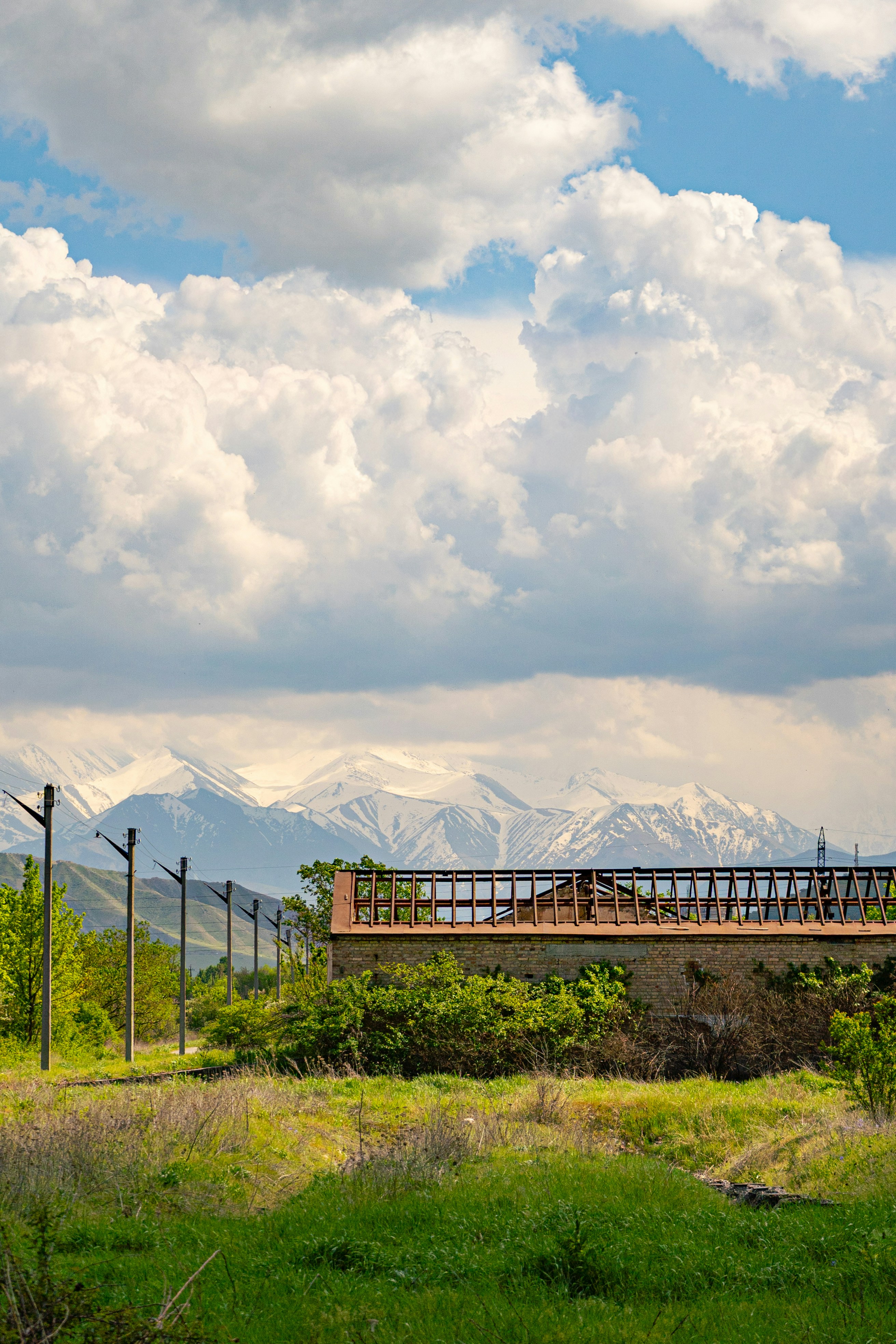 Railway Vista: Snow-tipped Peaks Beyond a Rustic Terrace