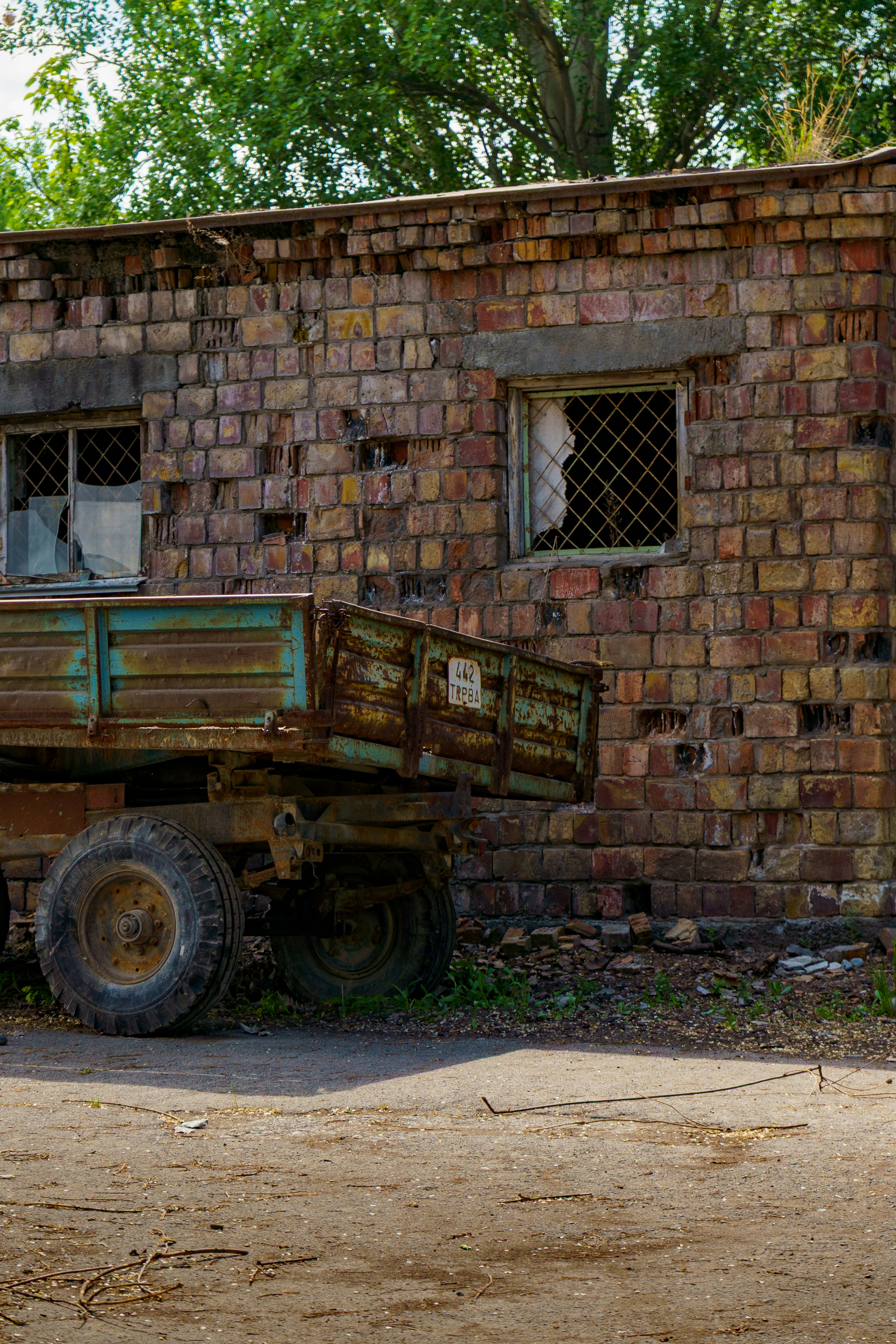 Abandoned Loader by a Weathered Brick Wall