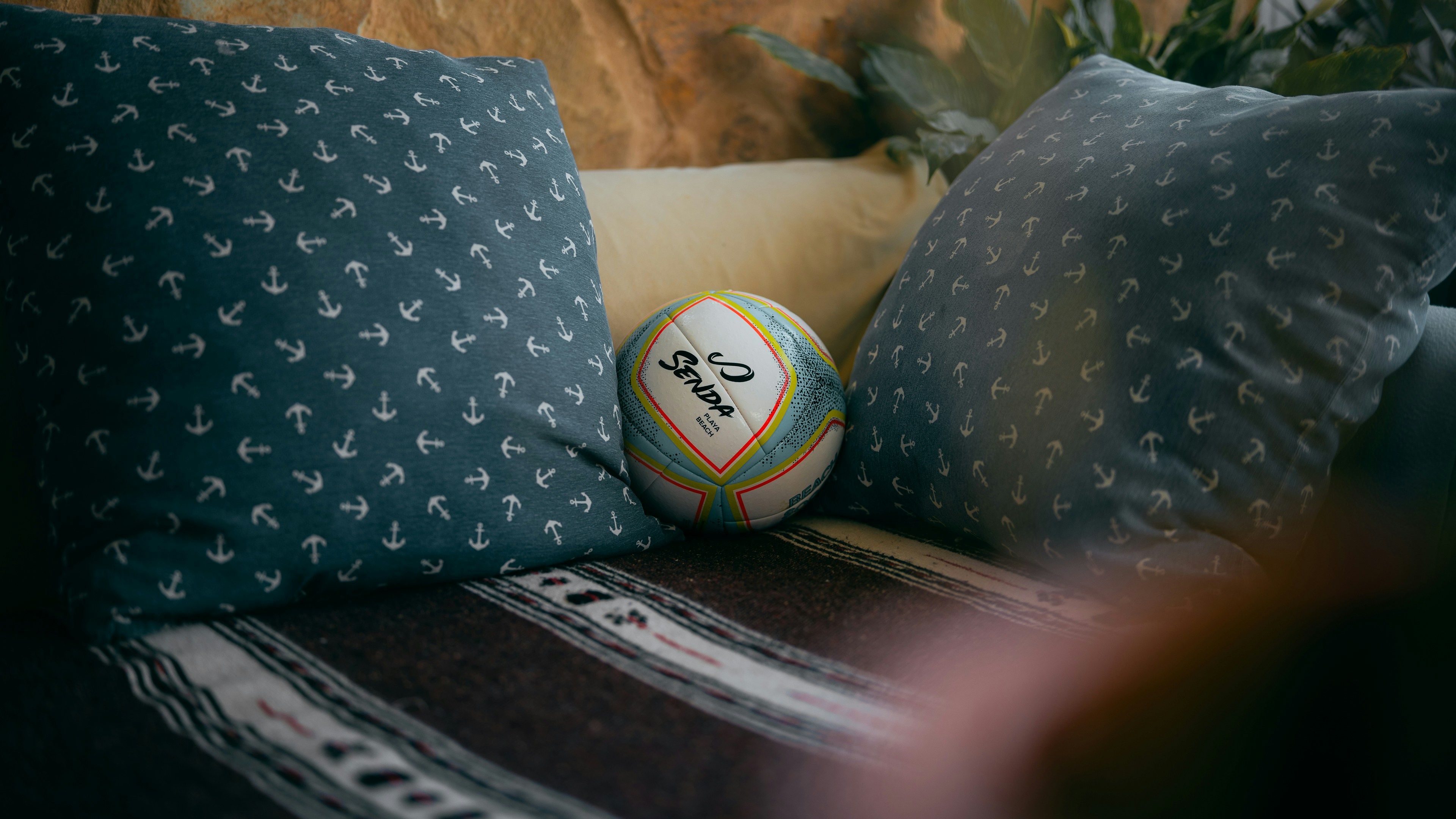 Sand Between Cushions: A Volleyball Resting by Cozy Pillows