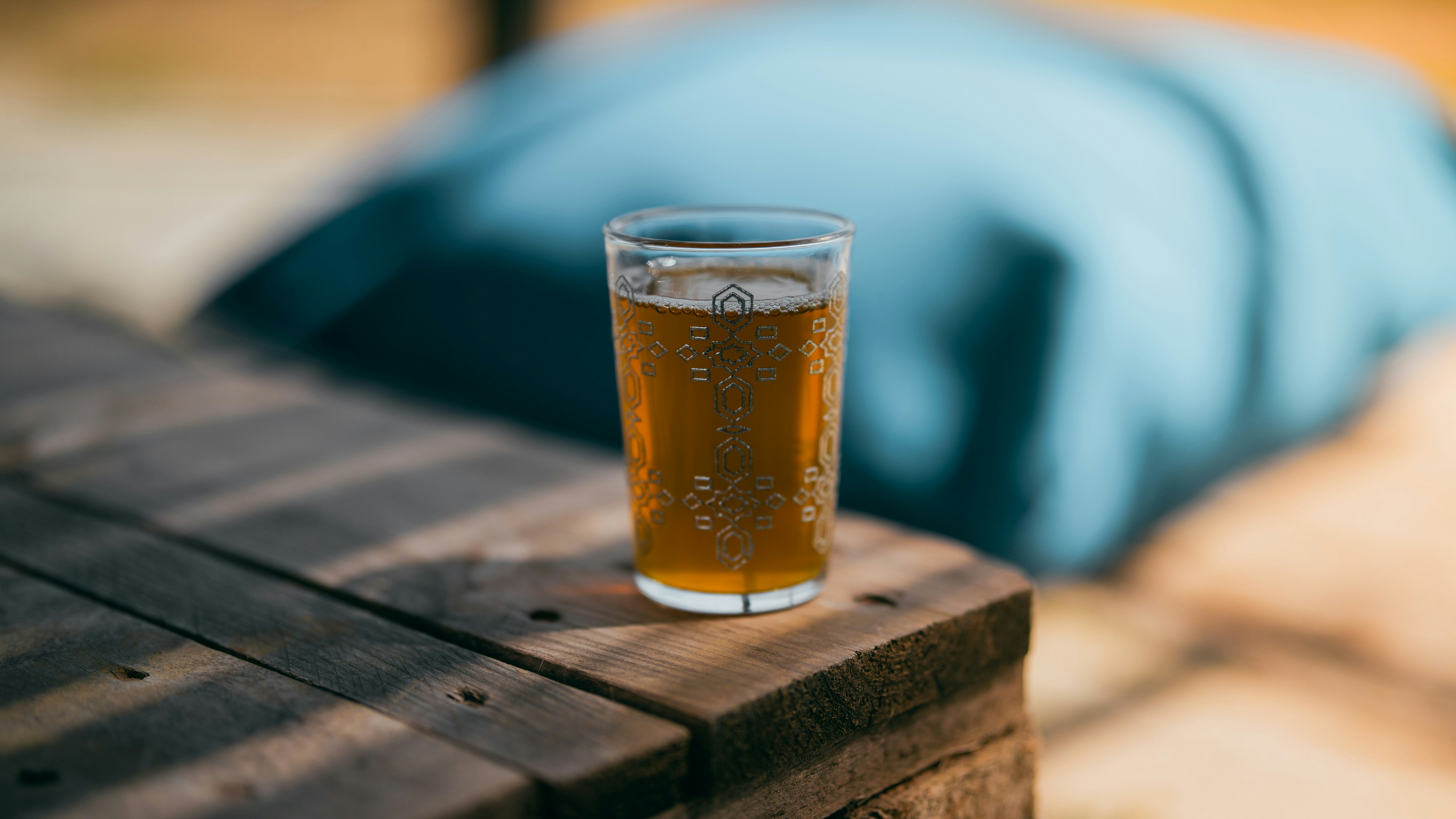 Amber Glow: A Glass of Sunlit Refreshment on Weathered Wood