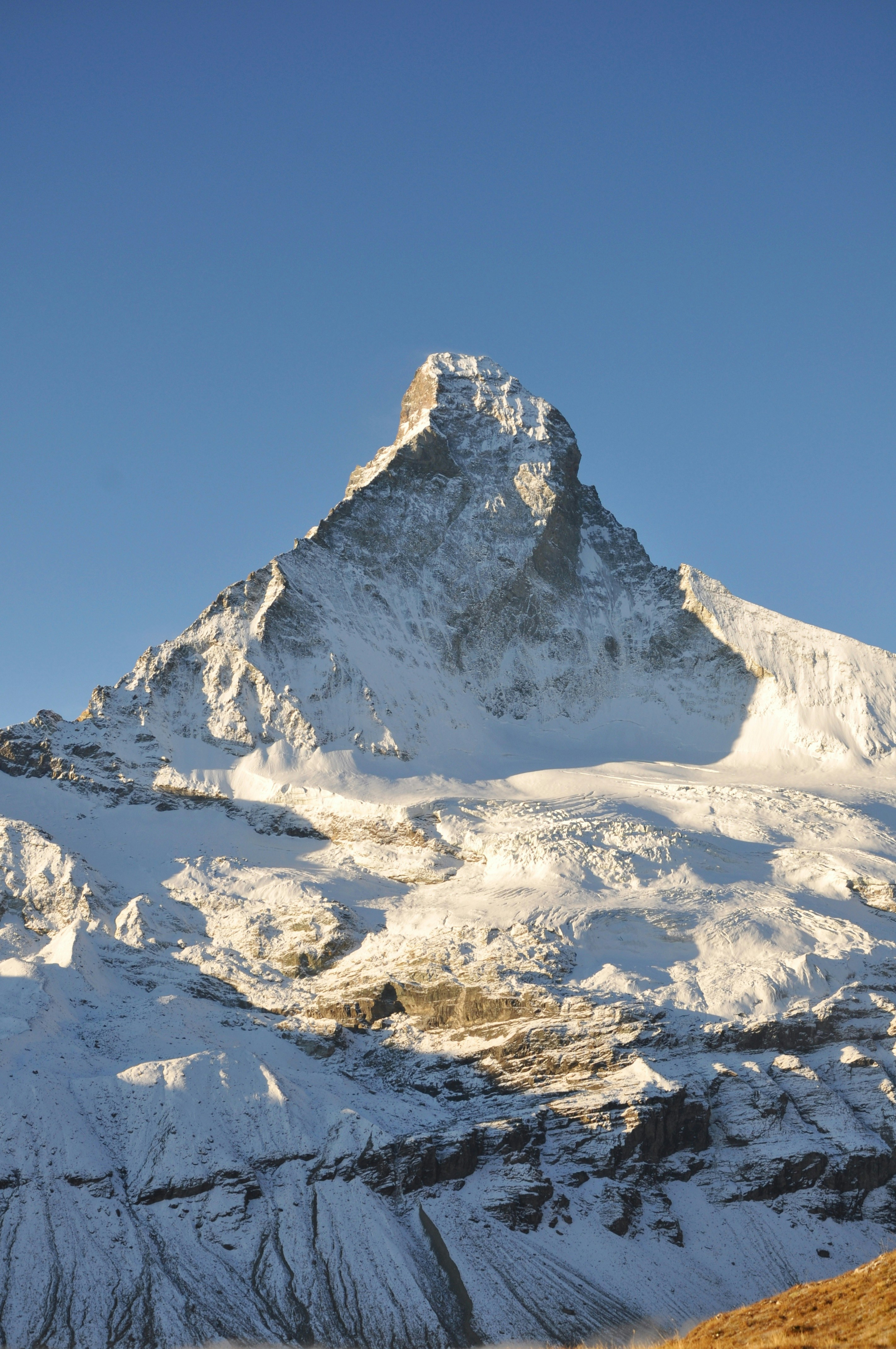  summit statue of light: snow-clad peak under clear blue sky