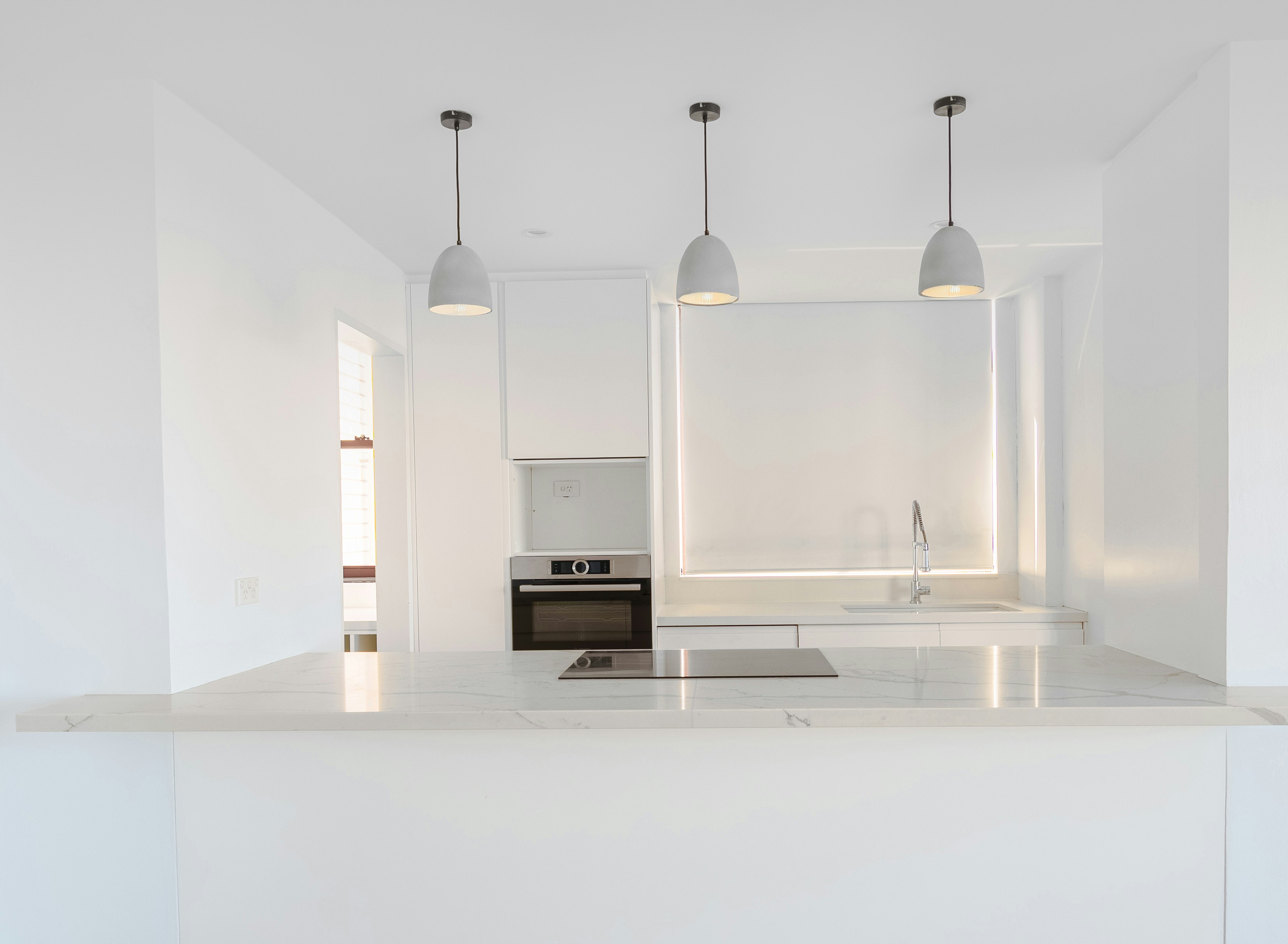 Minimalist White Kitchen with Center Island and Soft Natural Light