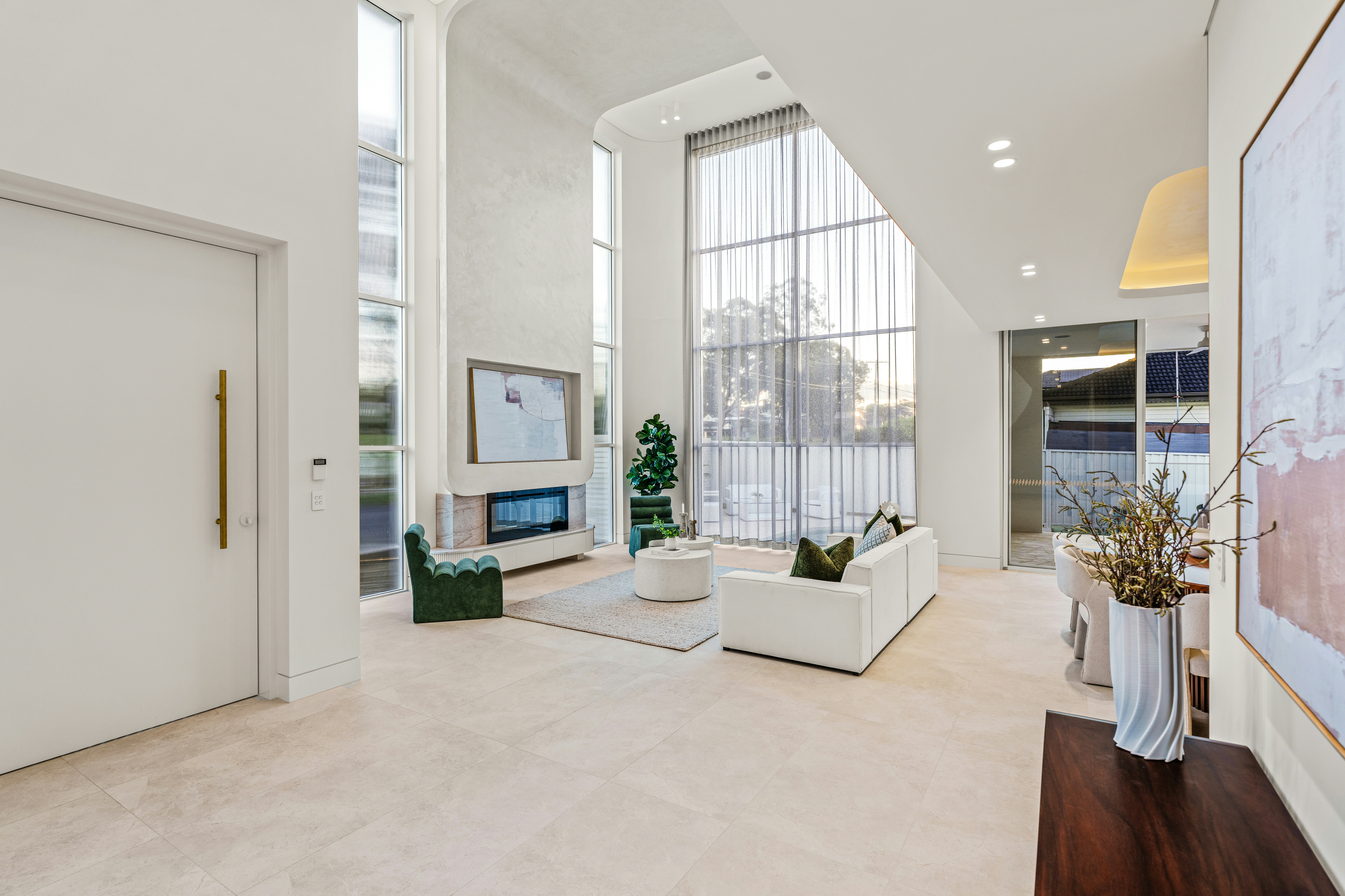 Modern living room with high ceilings and large windows.