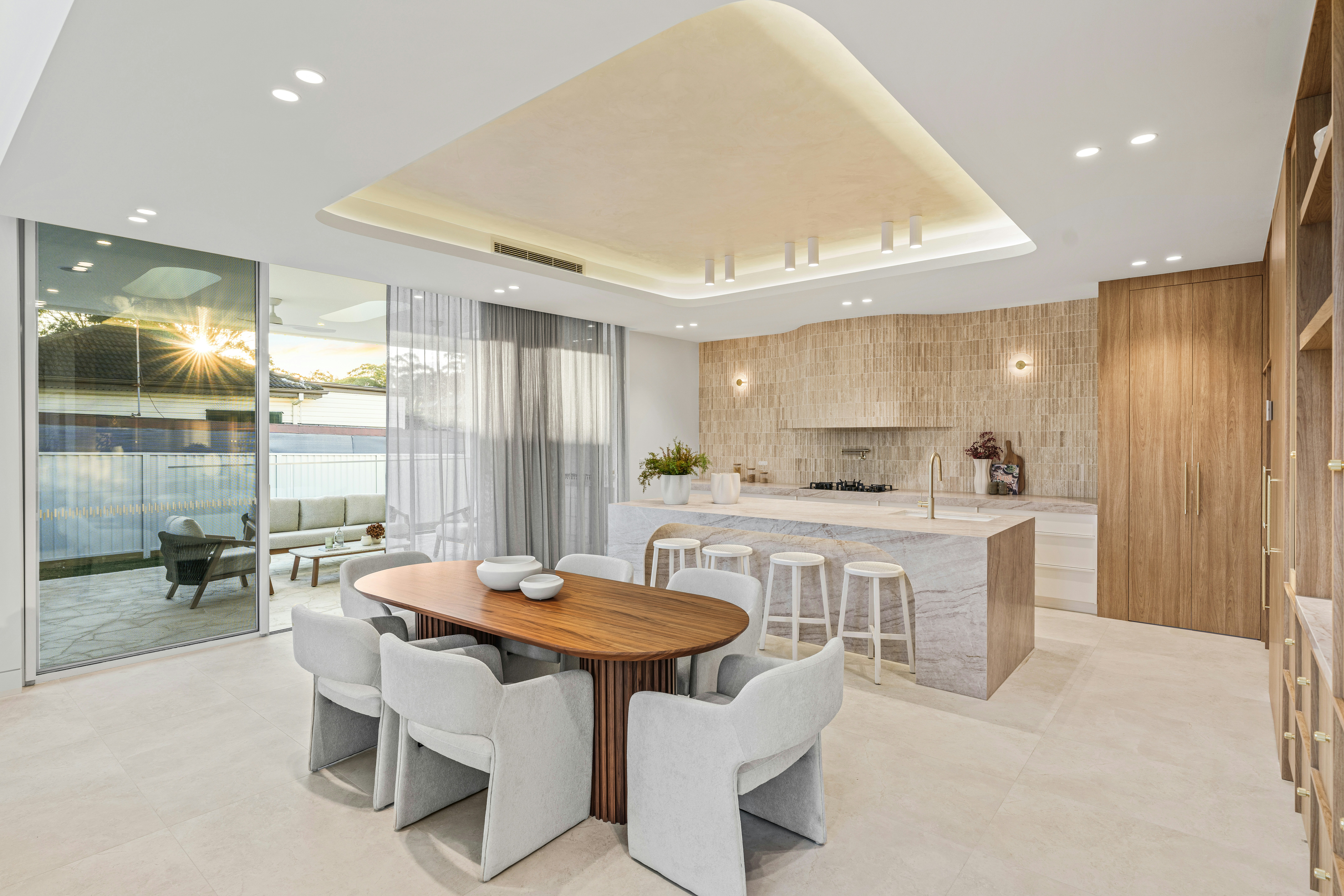 Sunlit Modern Kitchen: White Marble Island and Circular Dining Nook