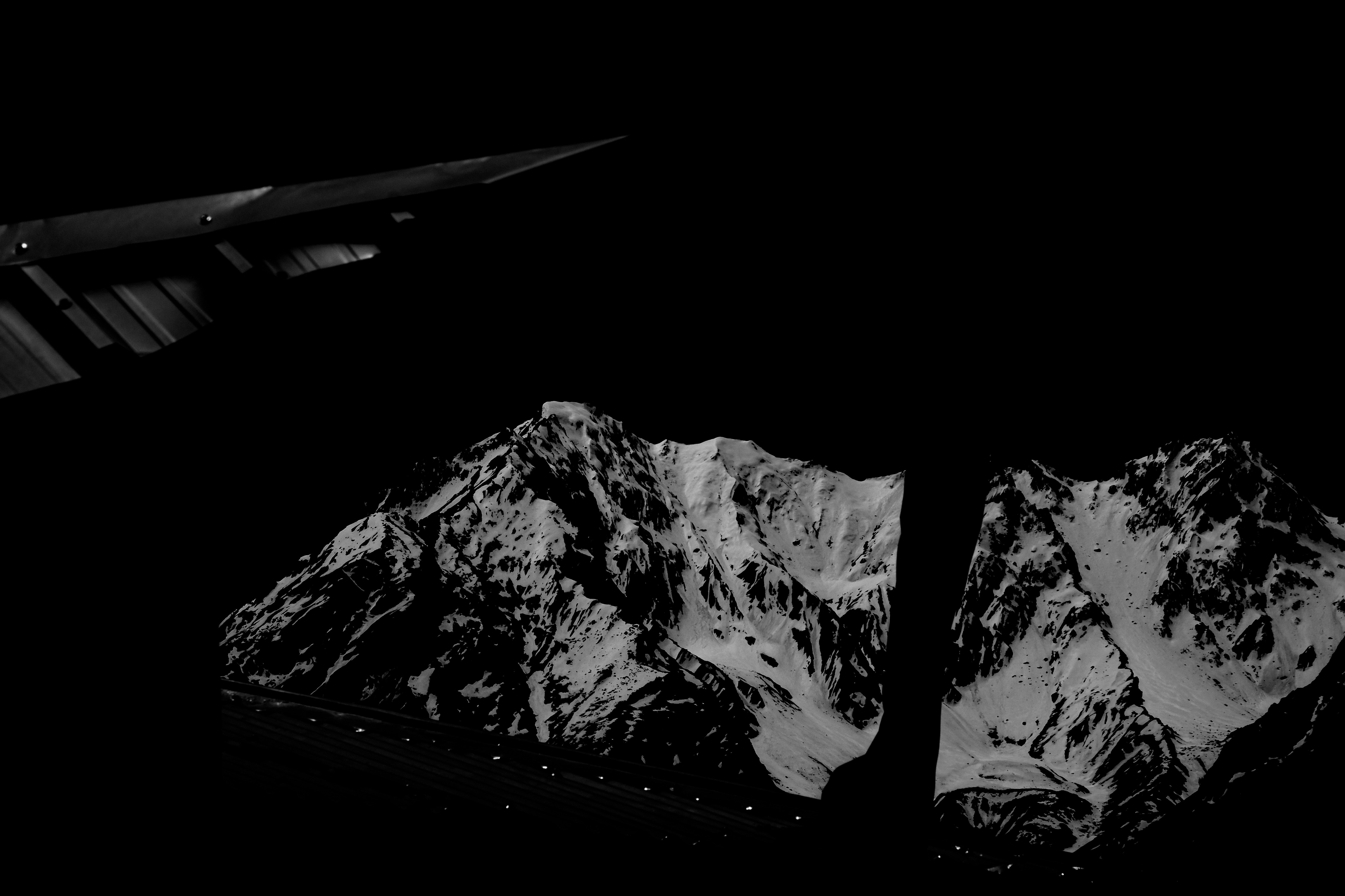 Aerial Silence: Snowbound Peaks Through a Window of Darkness