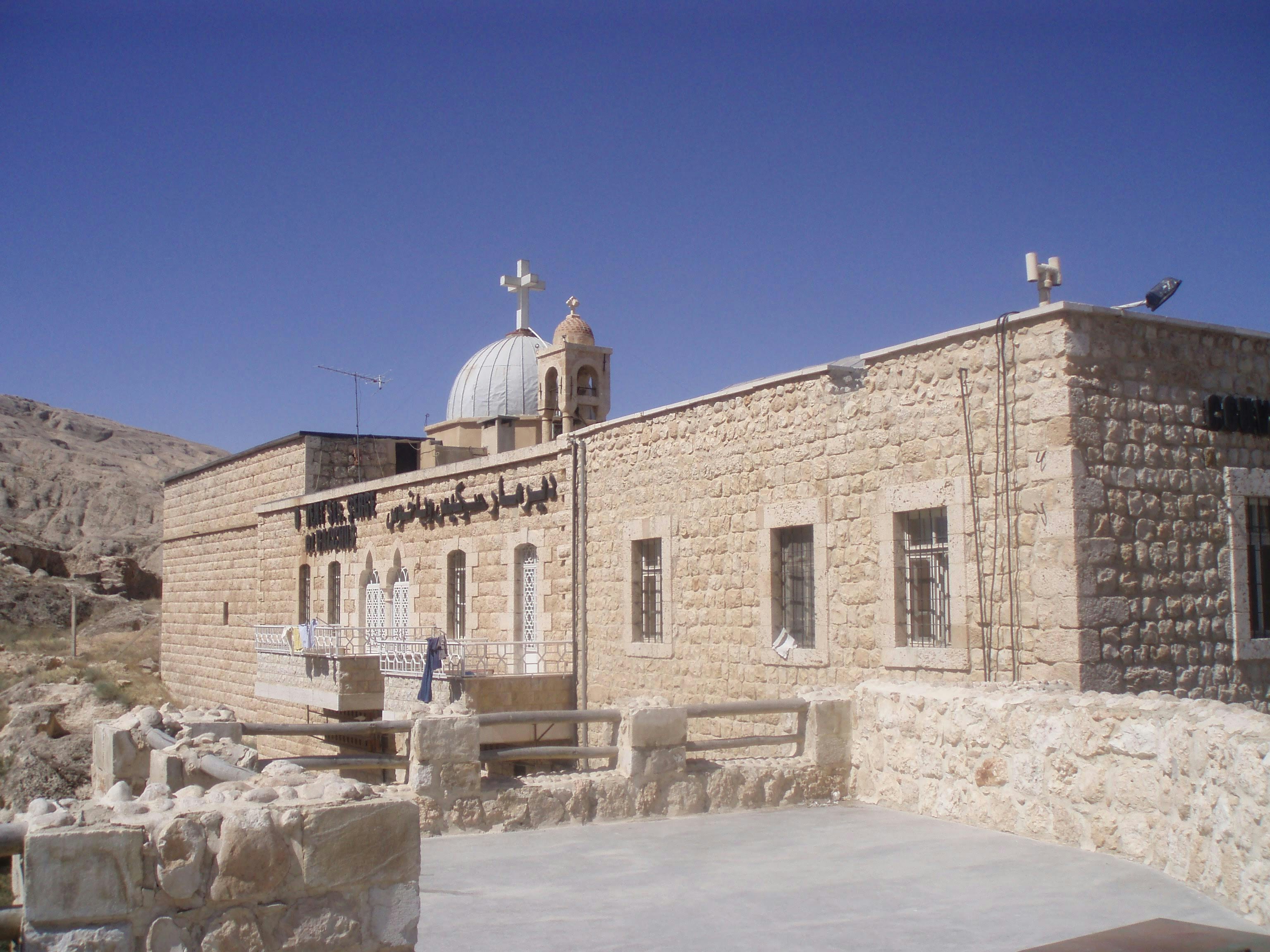 Ancient stone monastery building in a rocky desert landscape.