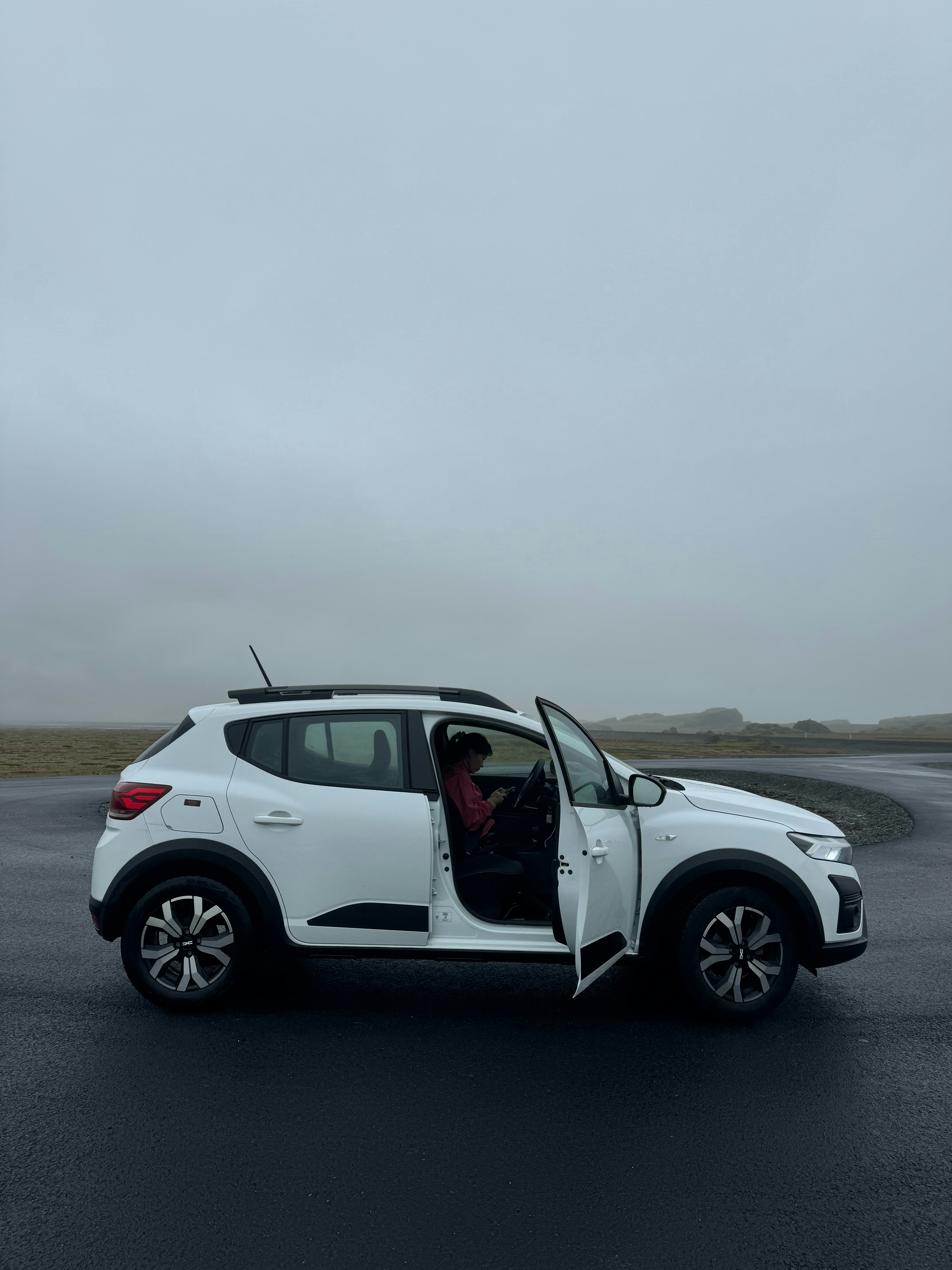 White SUV on Rain-Slicked Road with open passenger door