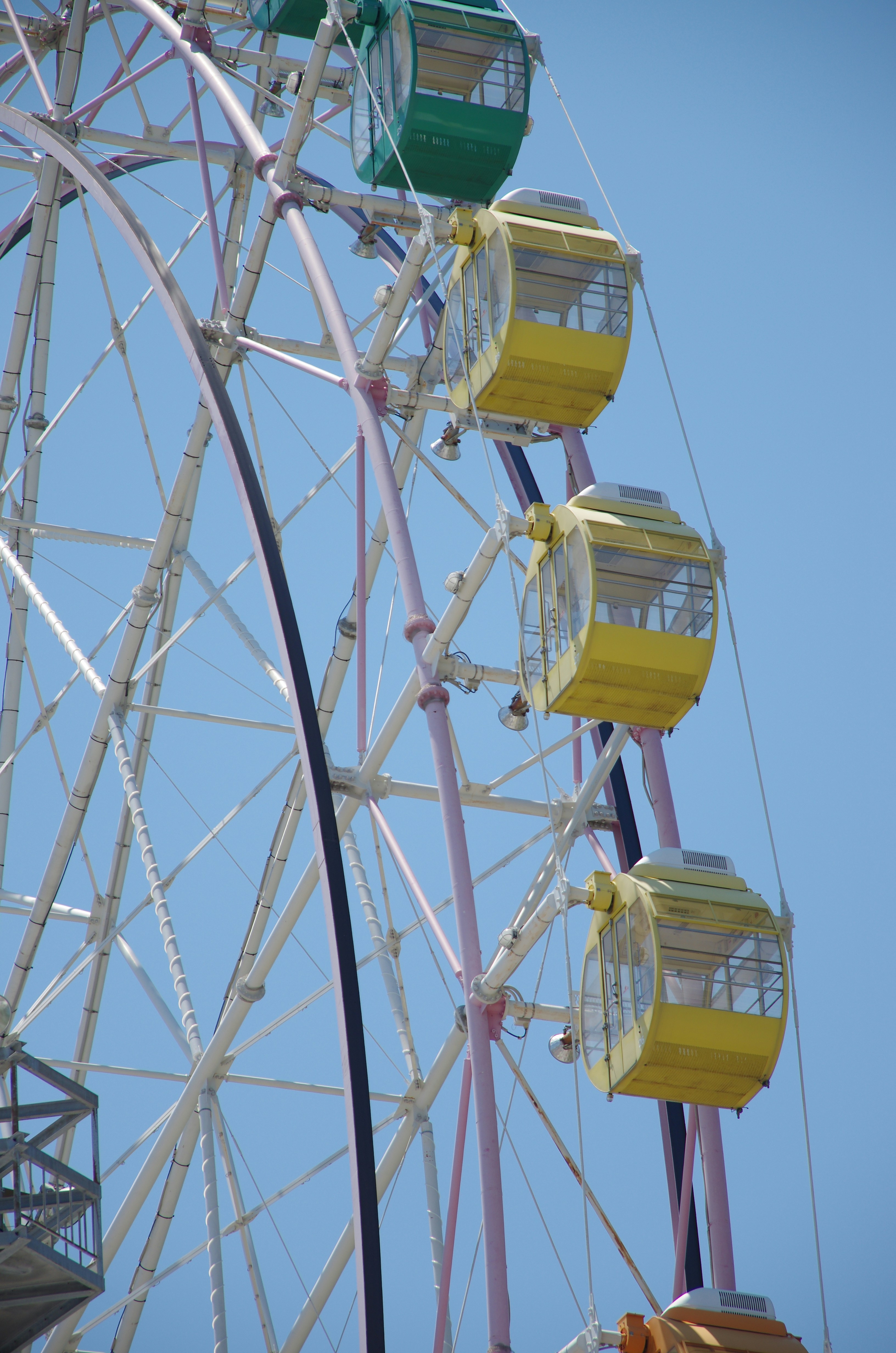 Colorful Gondolas Climb the Sky: A Ferris Wheel in Bright Daylight