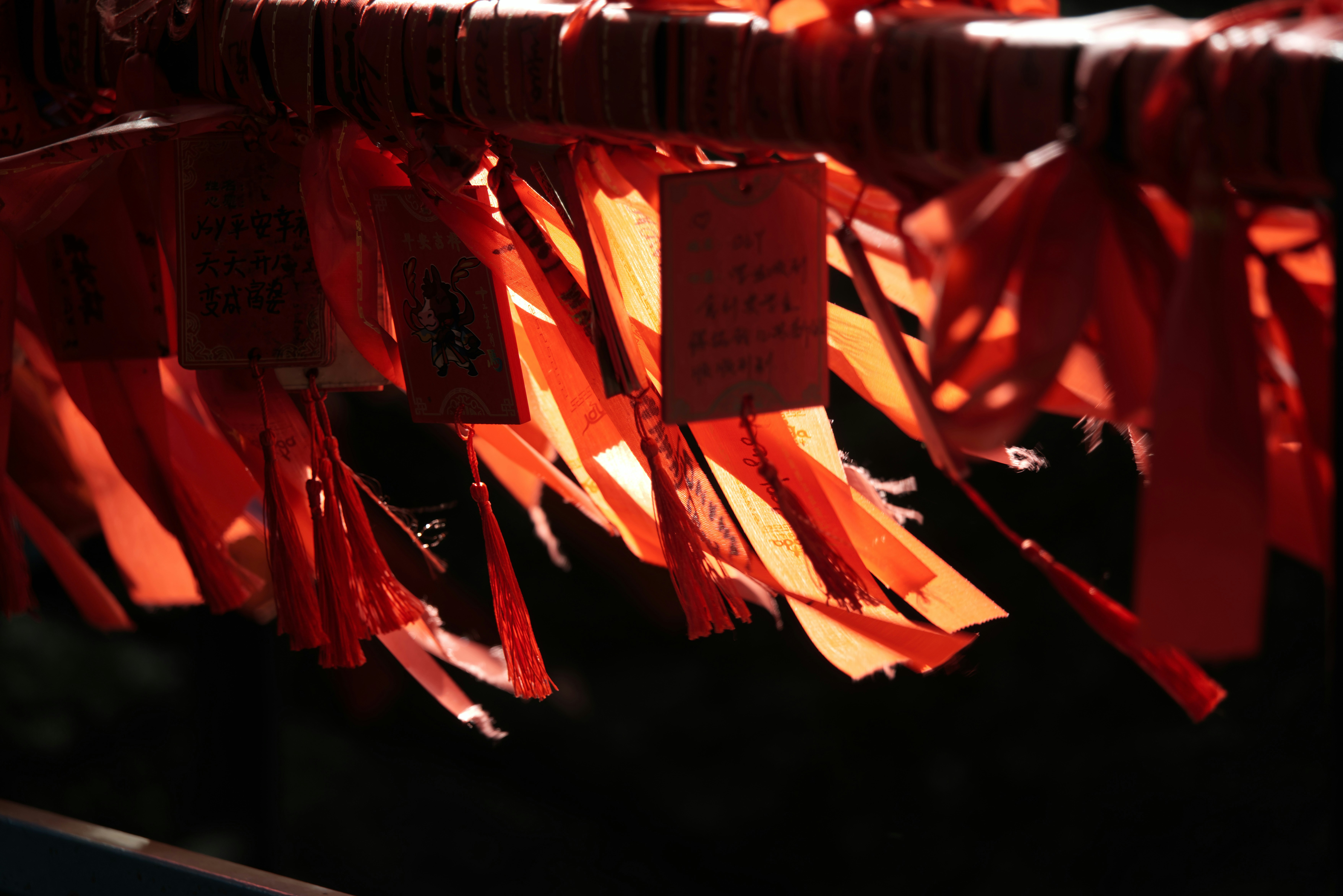 Red Prayer Tags in a Shaded Corridor