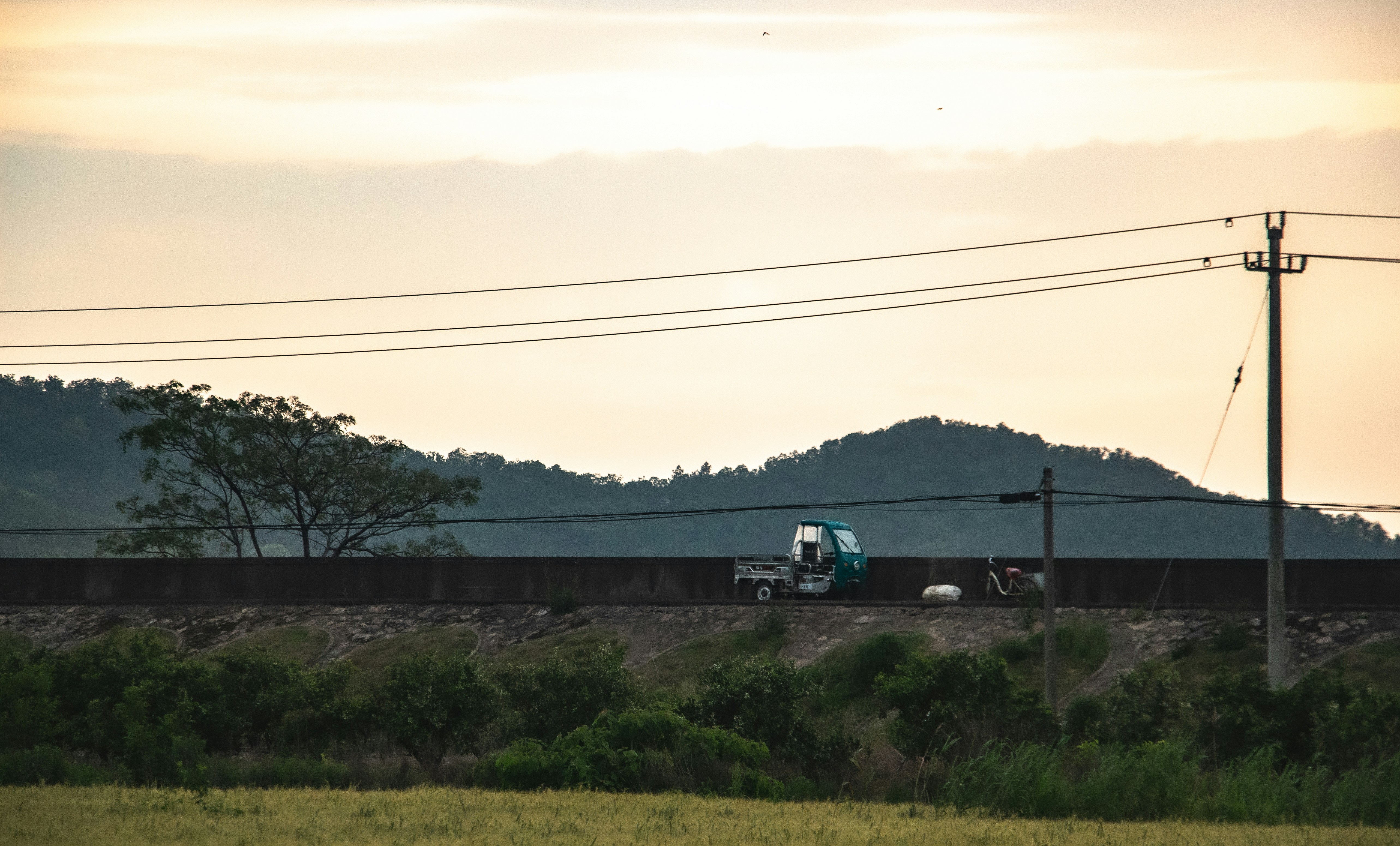 Midday Railline: A Quiet Truck Pauses Along the Horizon