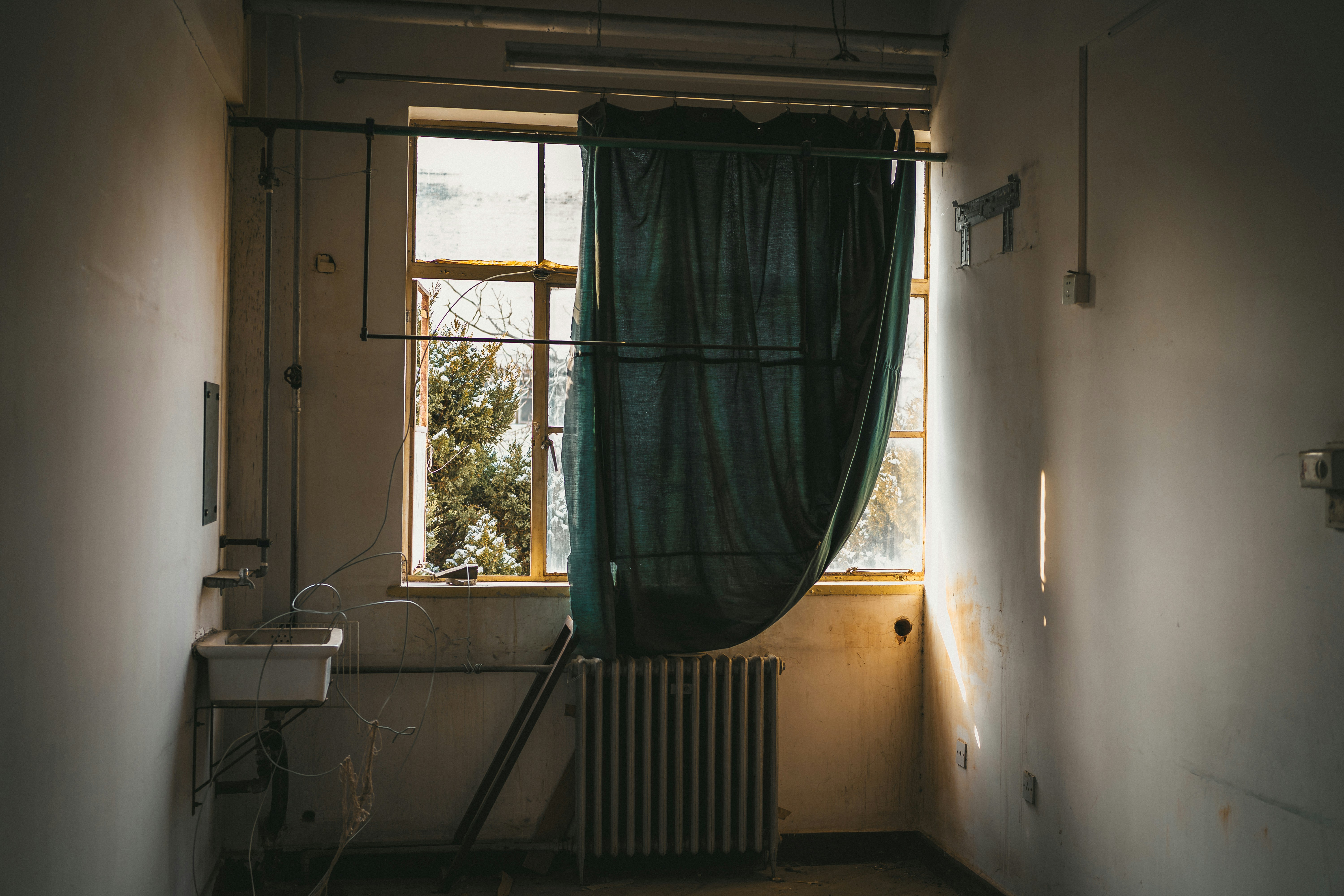 Dim Window Light Through a Tattered Curtain in a Bare Studio