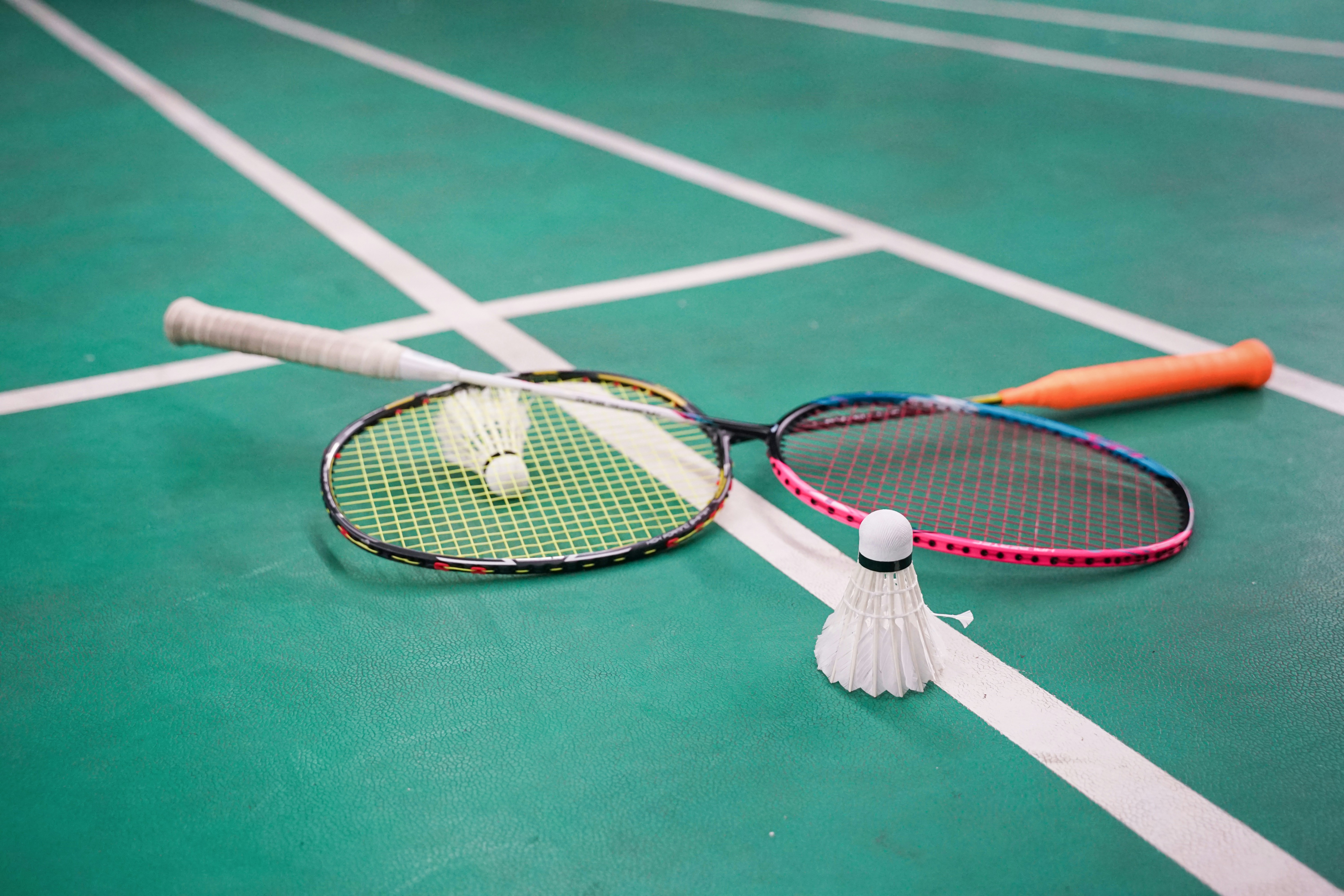 Folded Racquets and Shuttle on a Quiet Court