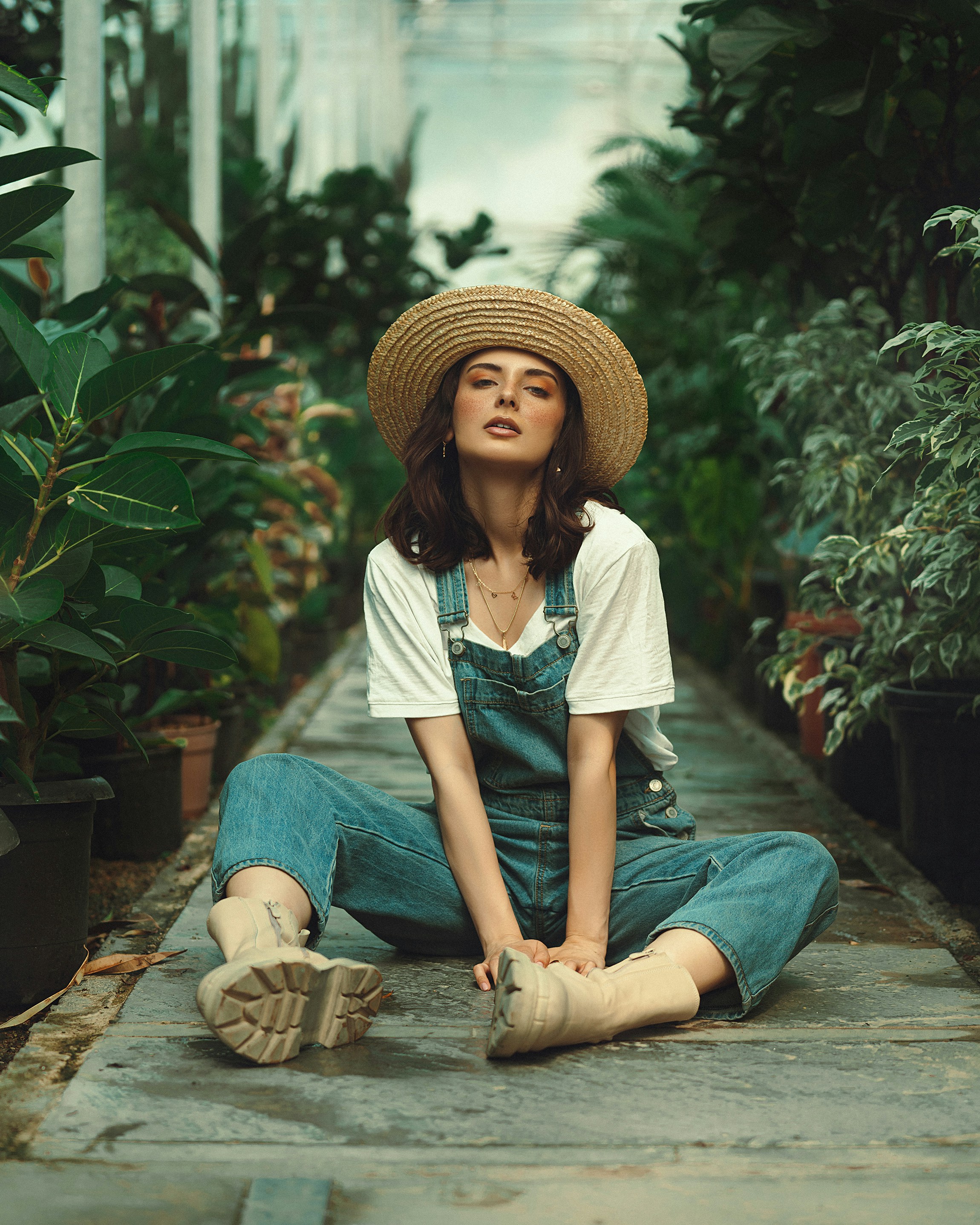 Straw Hat Stillness: A Quiet Portrait in the Greenhouse Path