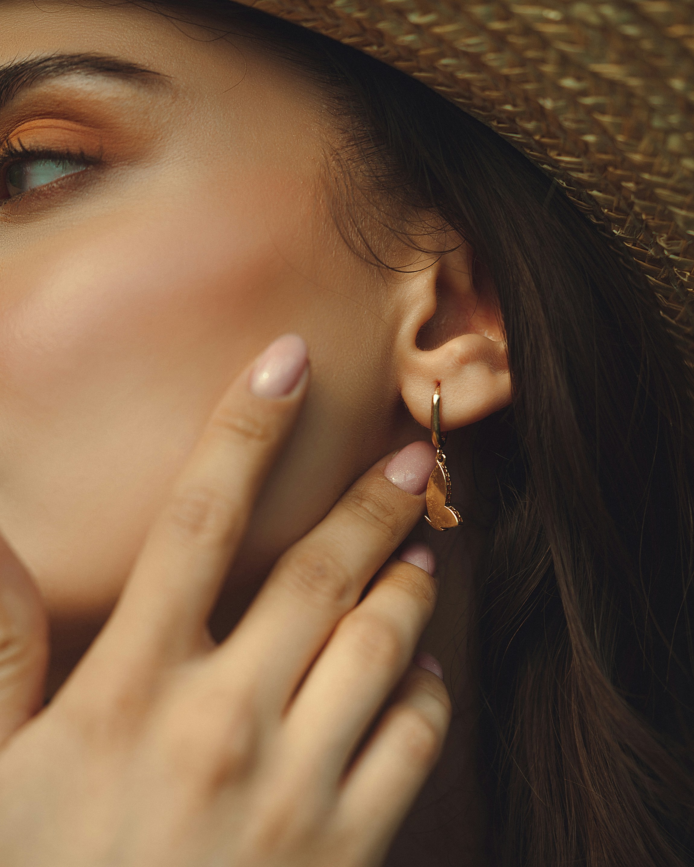 Woman in a straw hat with a golden earring.