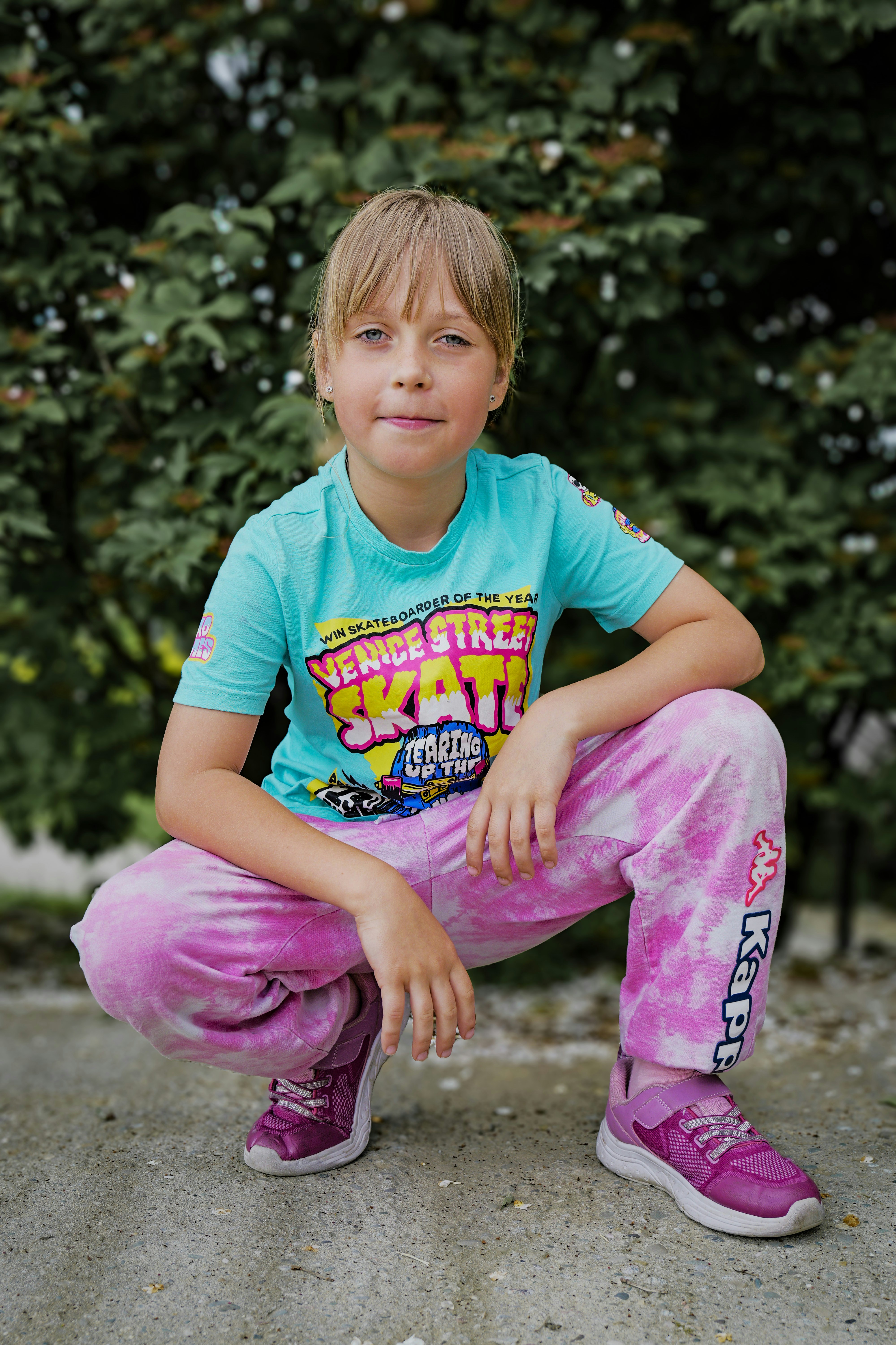 Lively Portrait: A Girl in Teal Top and Pink Sneakers in a Garden