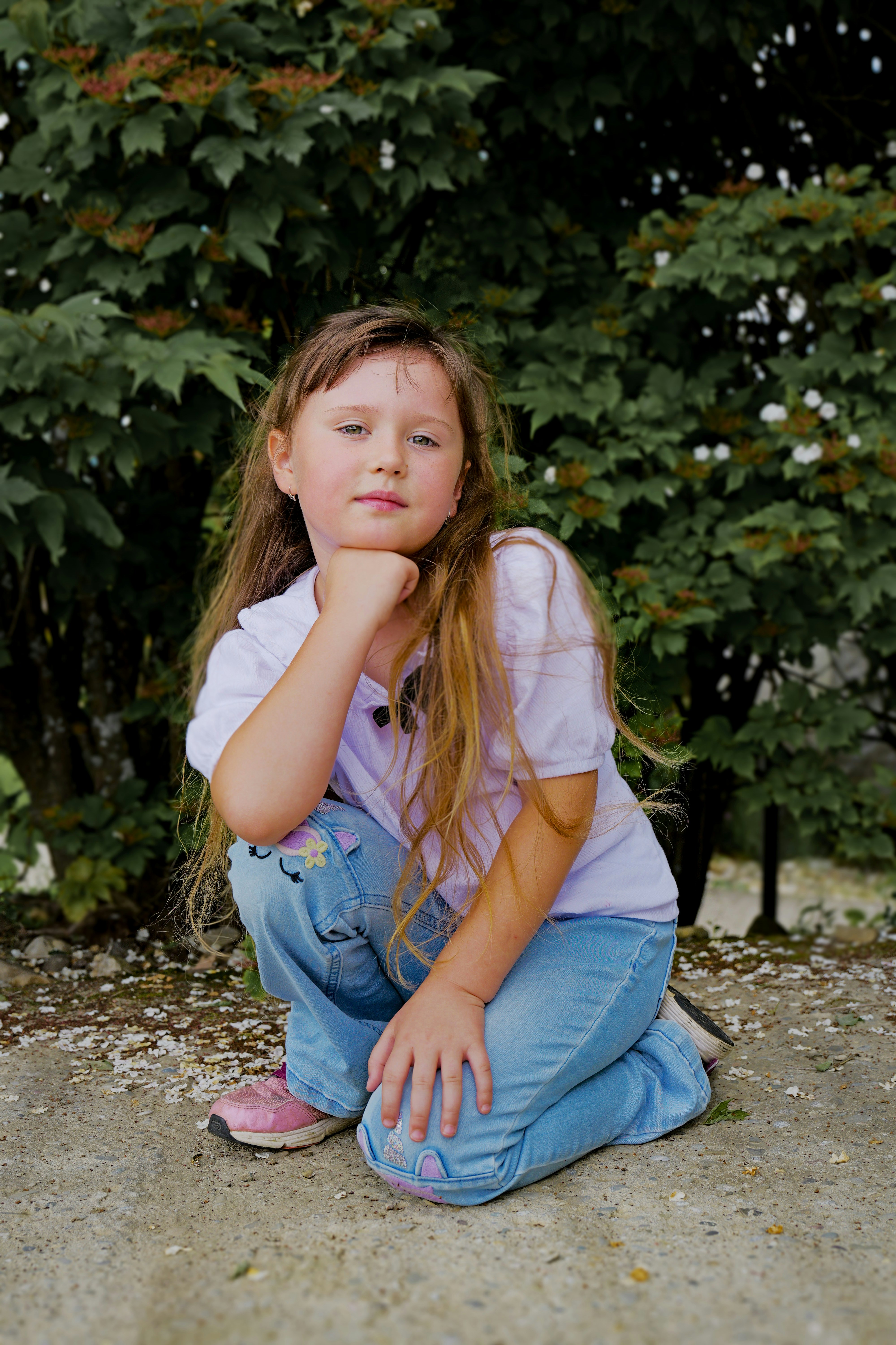 Portrait in Green: A Girl Lost in Thought on a Concrete Path