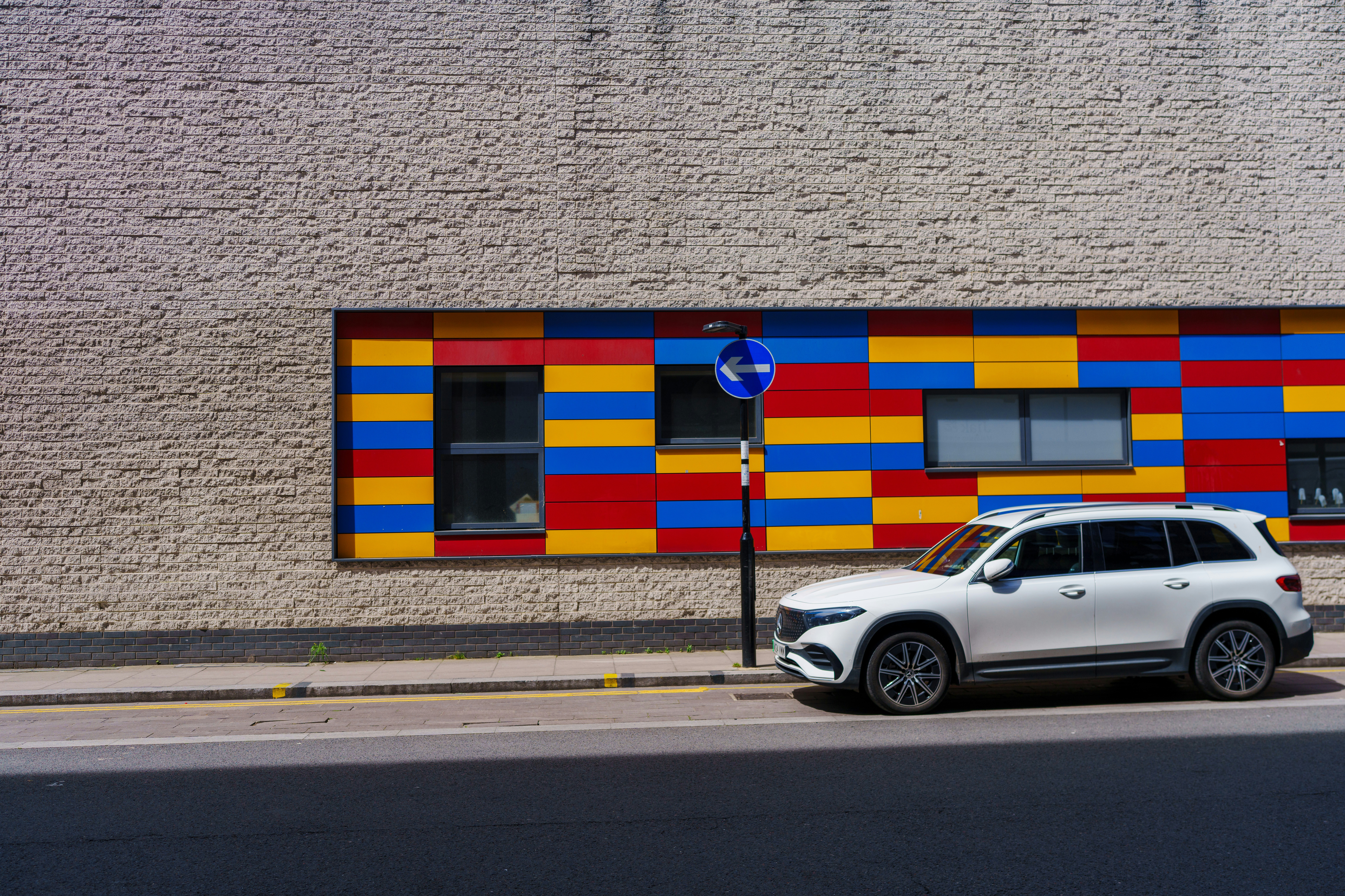 White SUV Quietly Anchors a Colorful Facade
