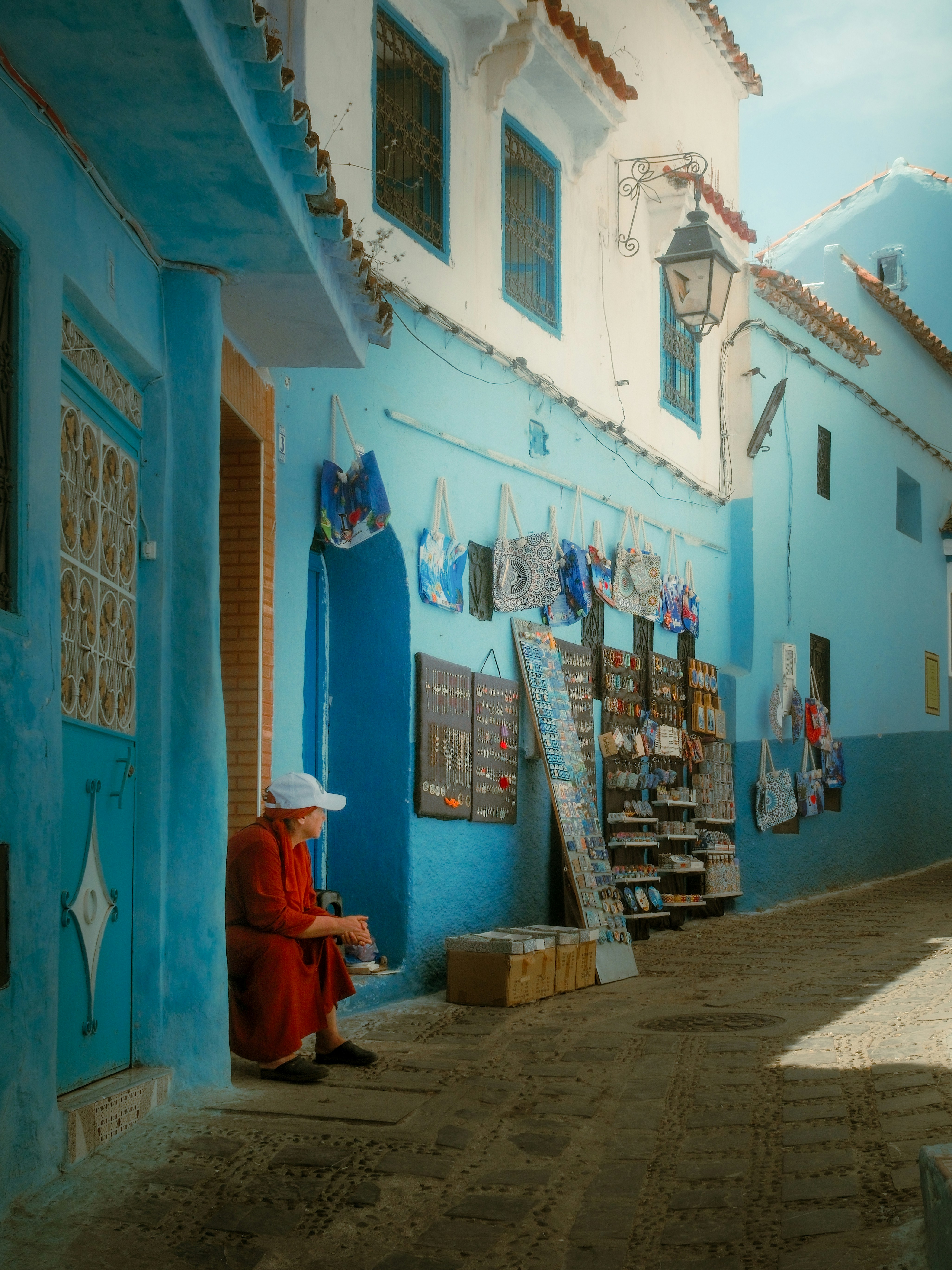 Azure street with a solitary monk by a turquoise wall