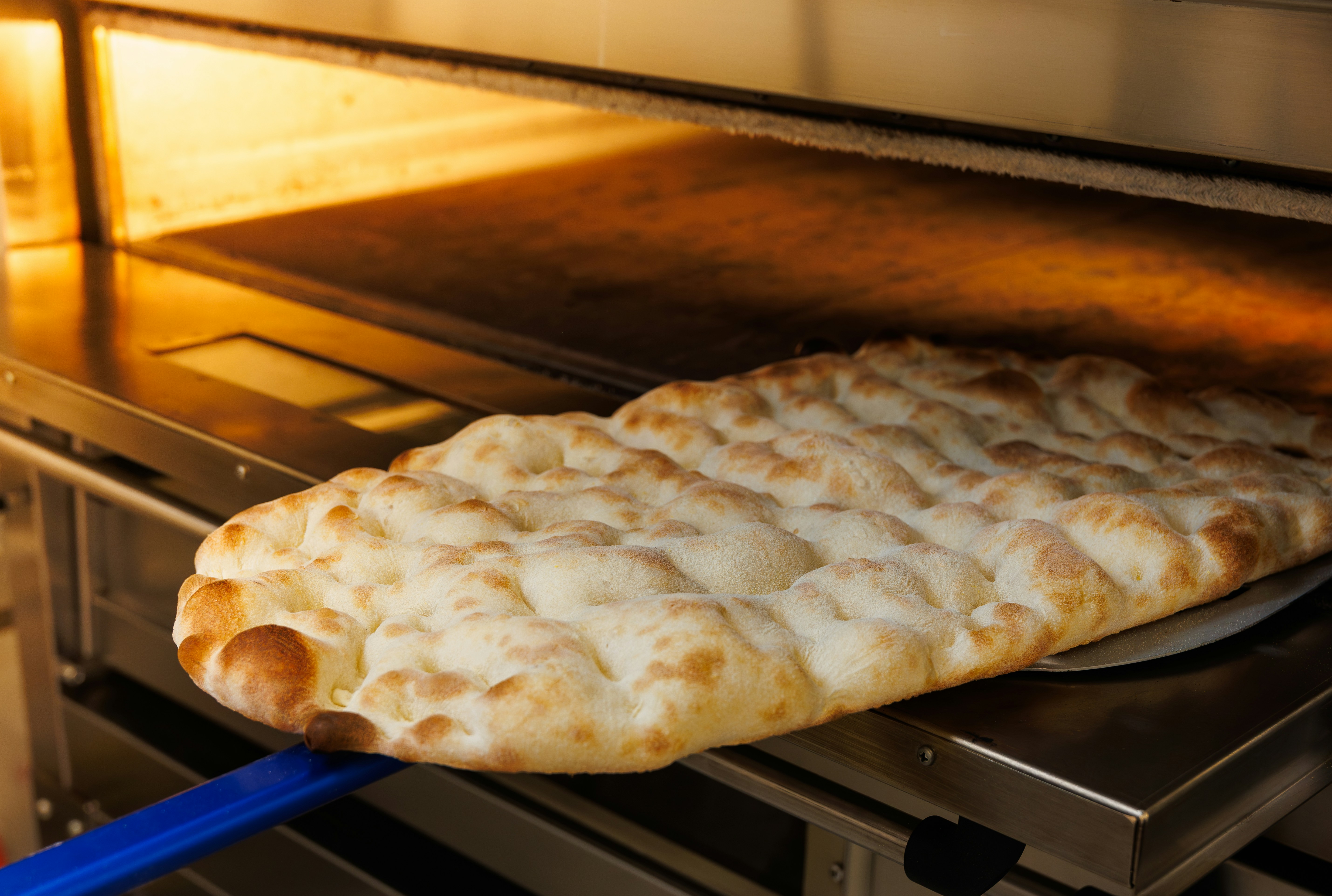 Golden Flatbread Emerging from a Bakery Ember