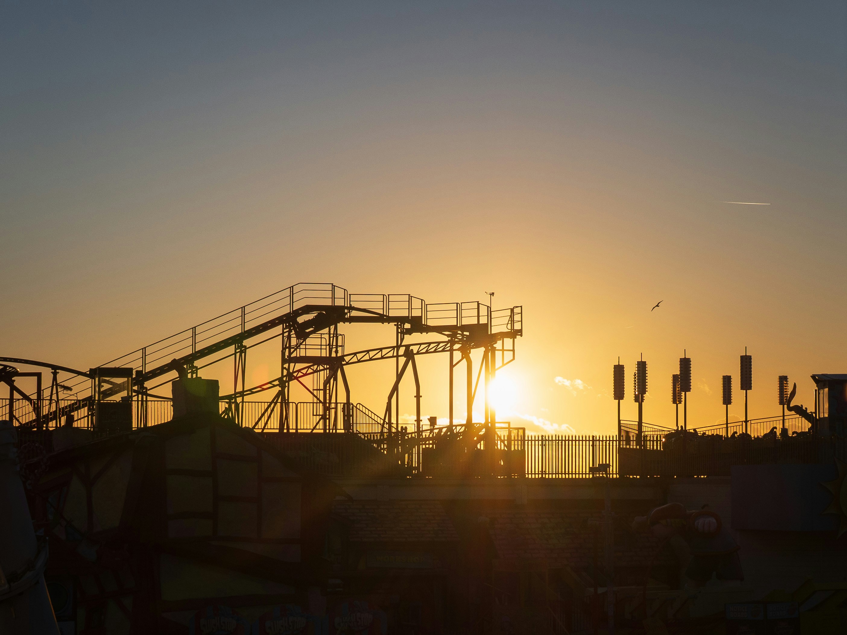 Sunlit Pier at Dusk: Silhouettes and Railing Structures Against a Golden Sky