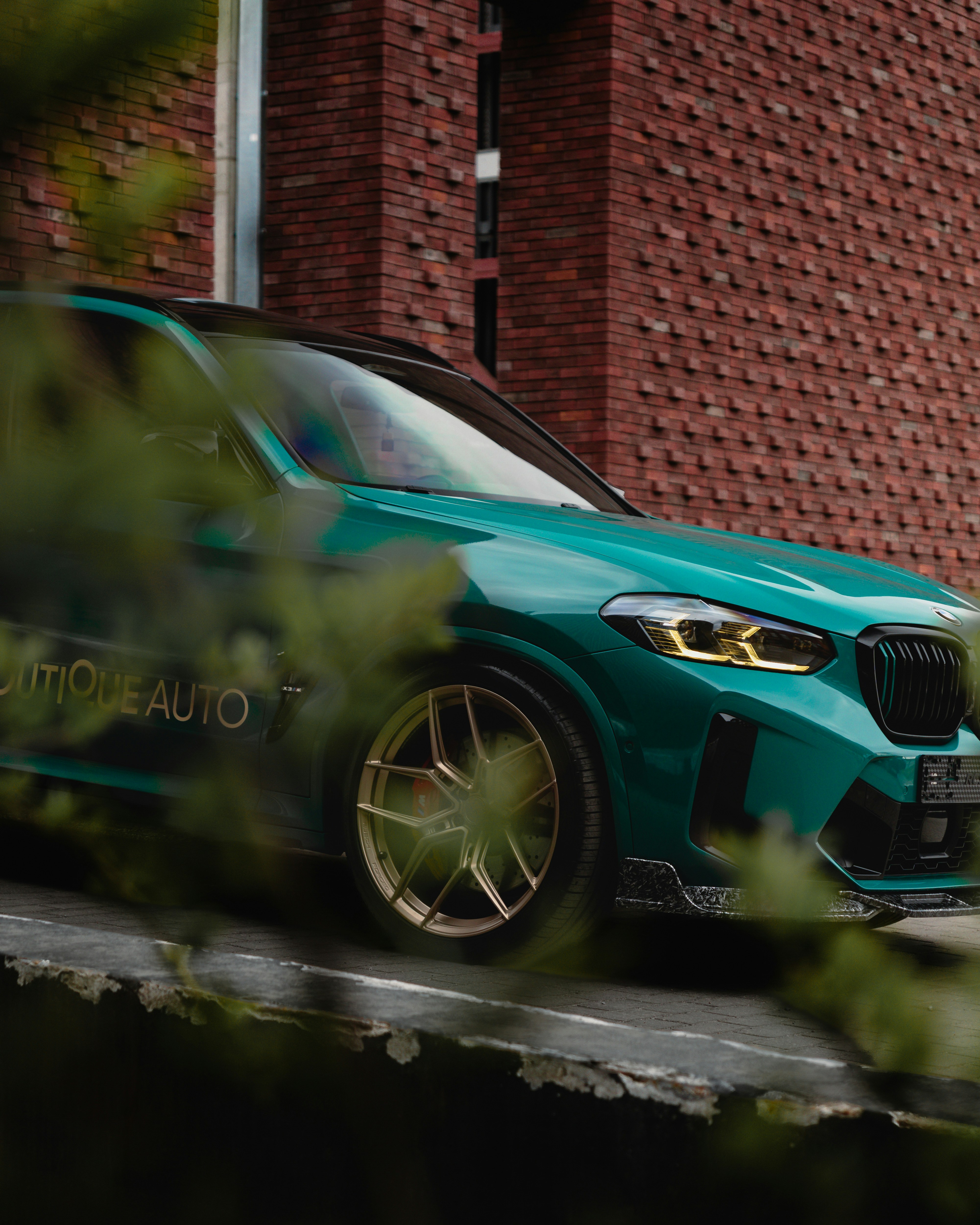 Turquoise BMW Emerges from Urban Greenery