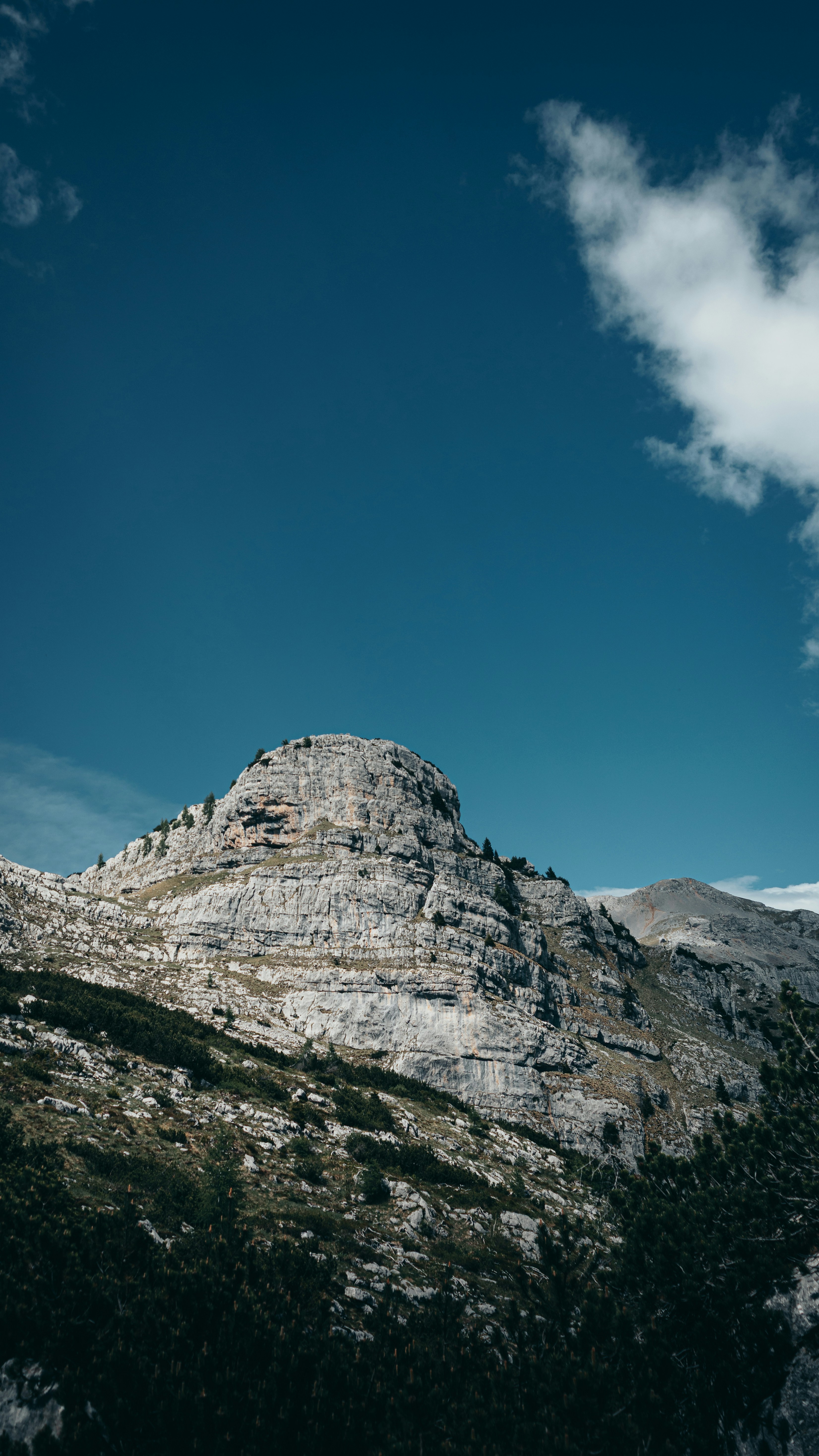 A majestic rocky mountain under a clear blue sky.