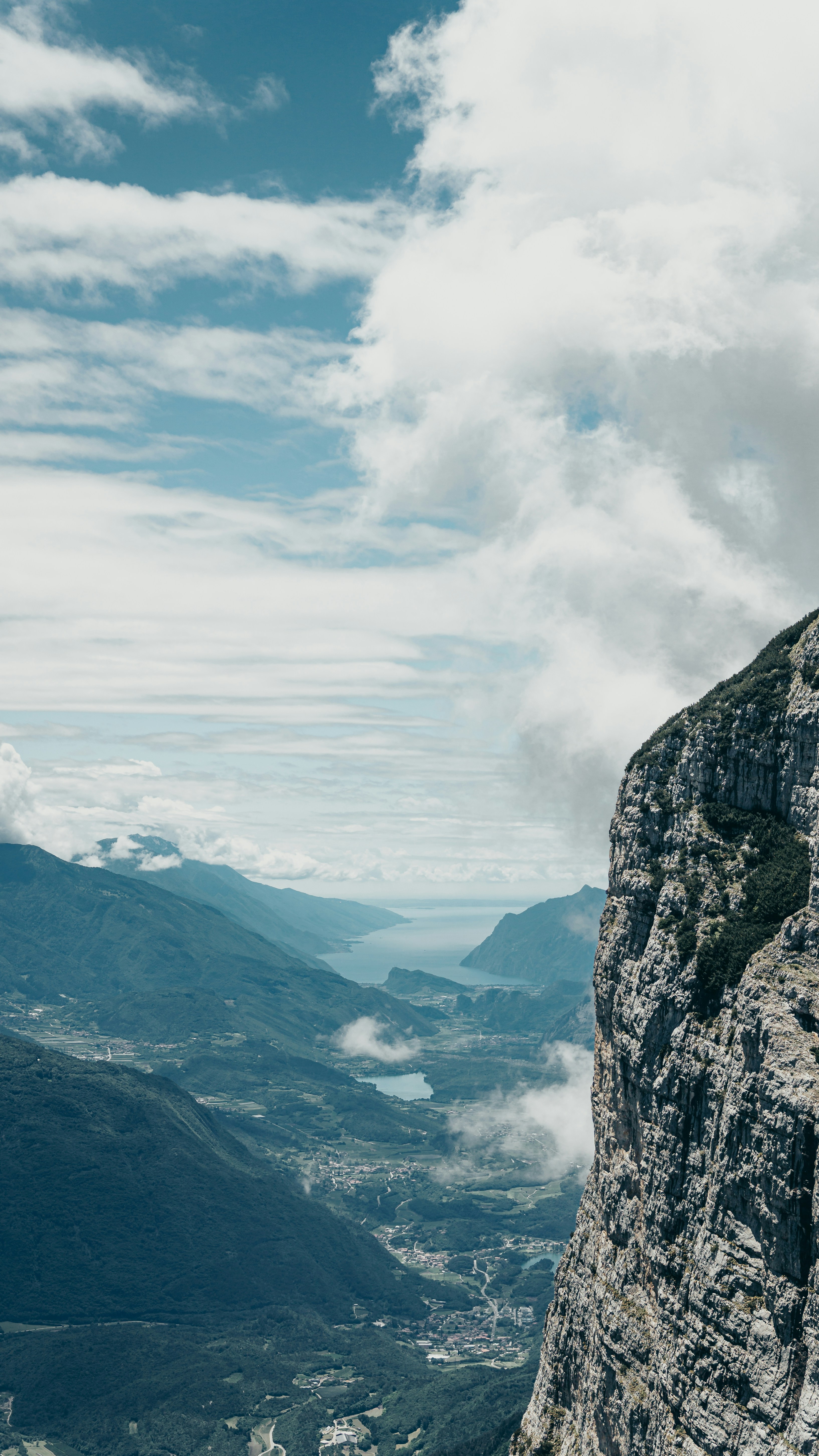 Vertical Cliff Banner: A Lone Mountain Towering Over a Serene Valley