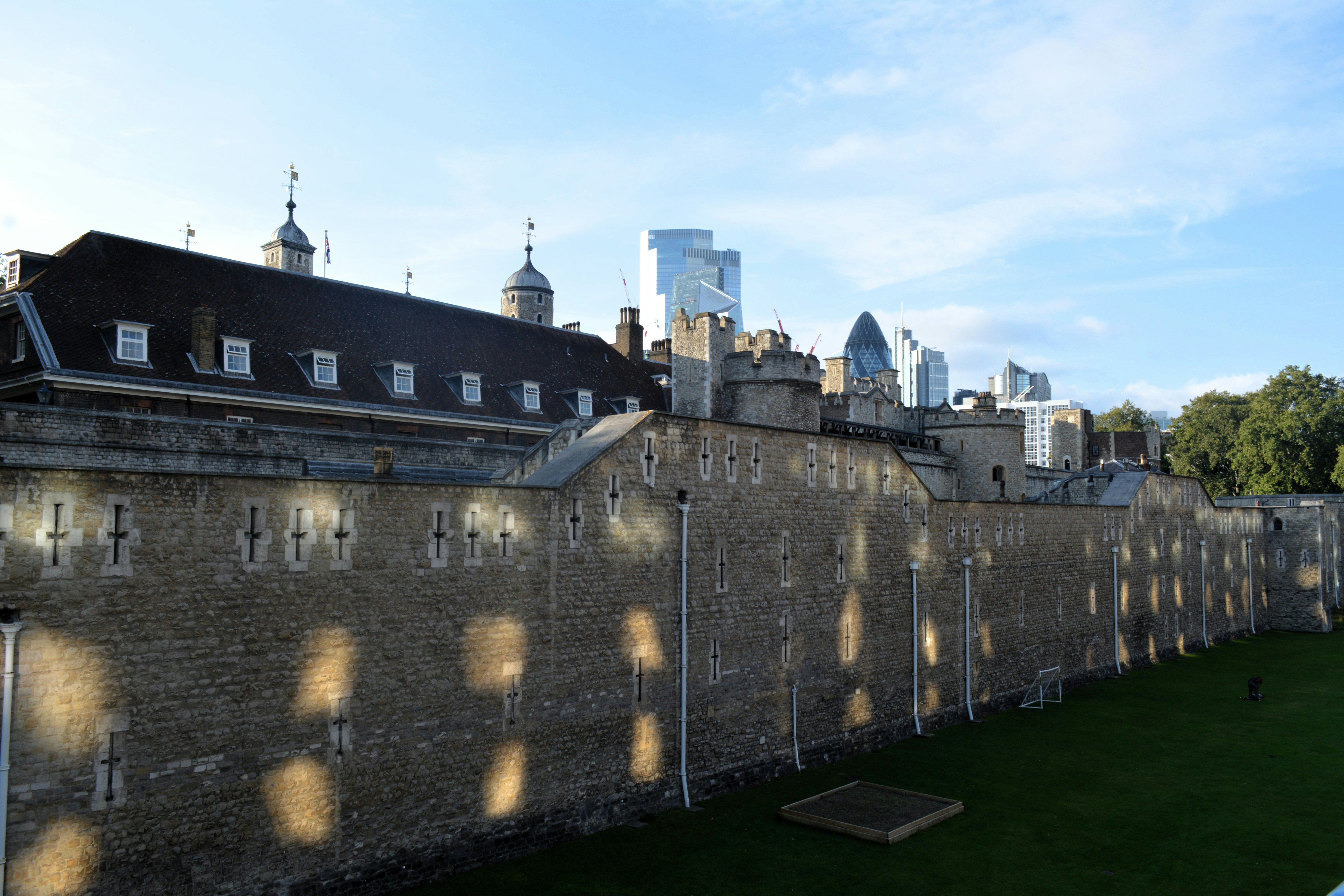 Sunlit bastion: ancient stone walls under a modern skyline
