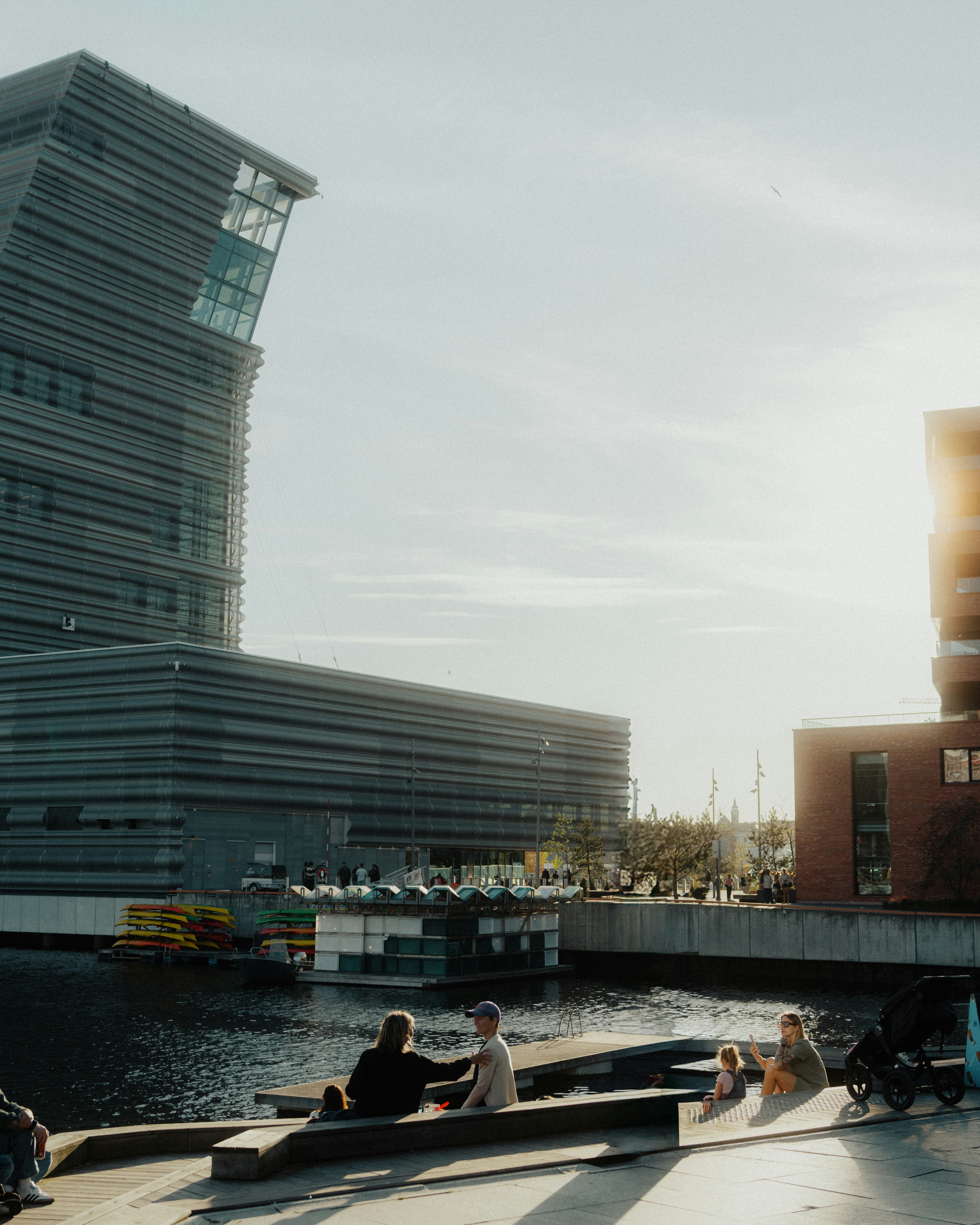 Sunlit Pavilion by the Water: People Relaxing Along the Riverside