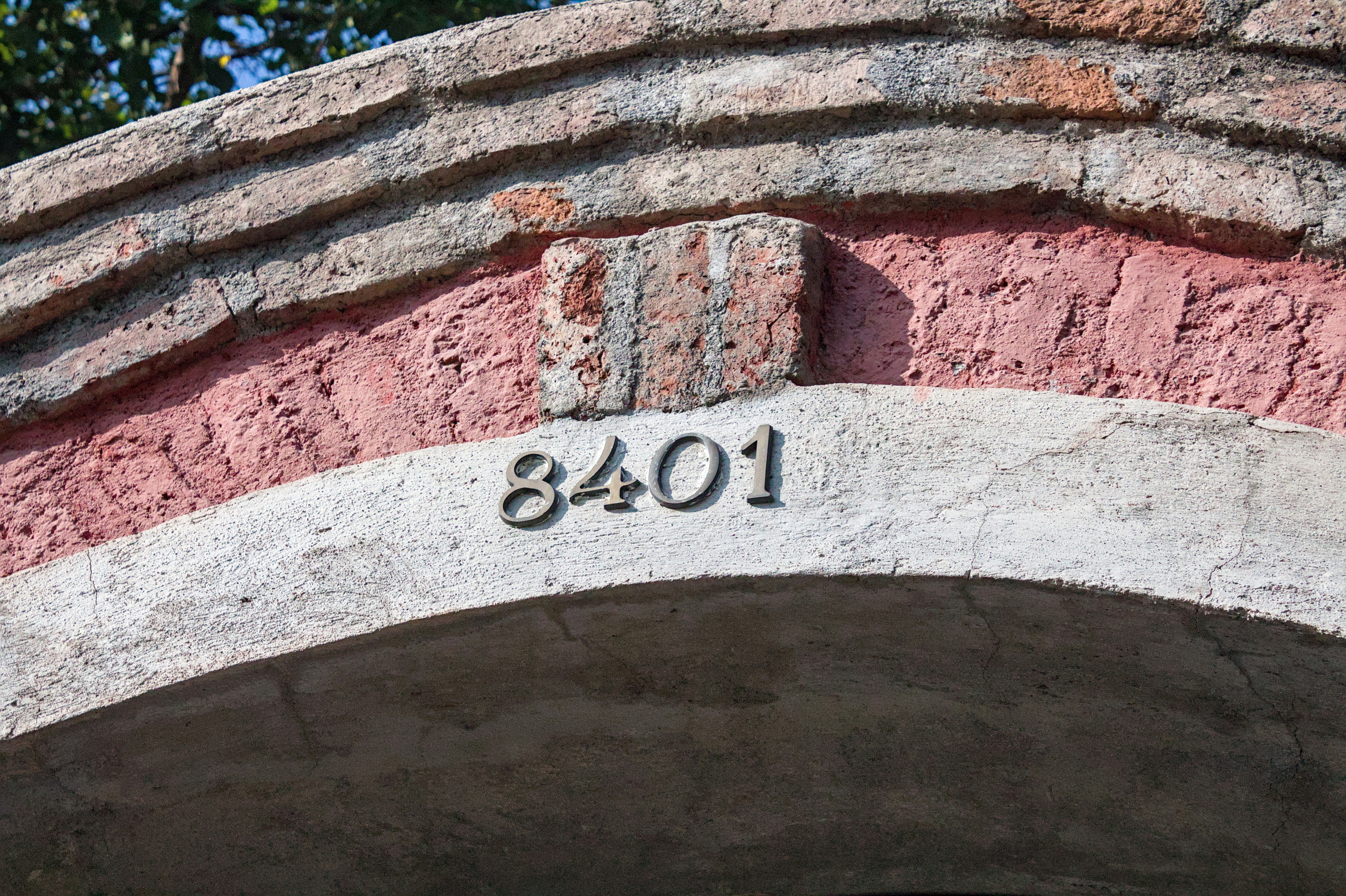 Archway Ledger: The Weathered Address 8401 on a Brick Facade