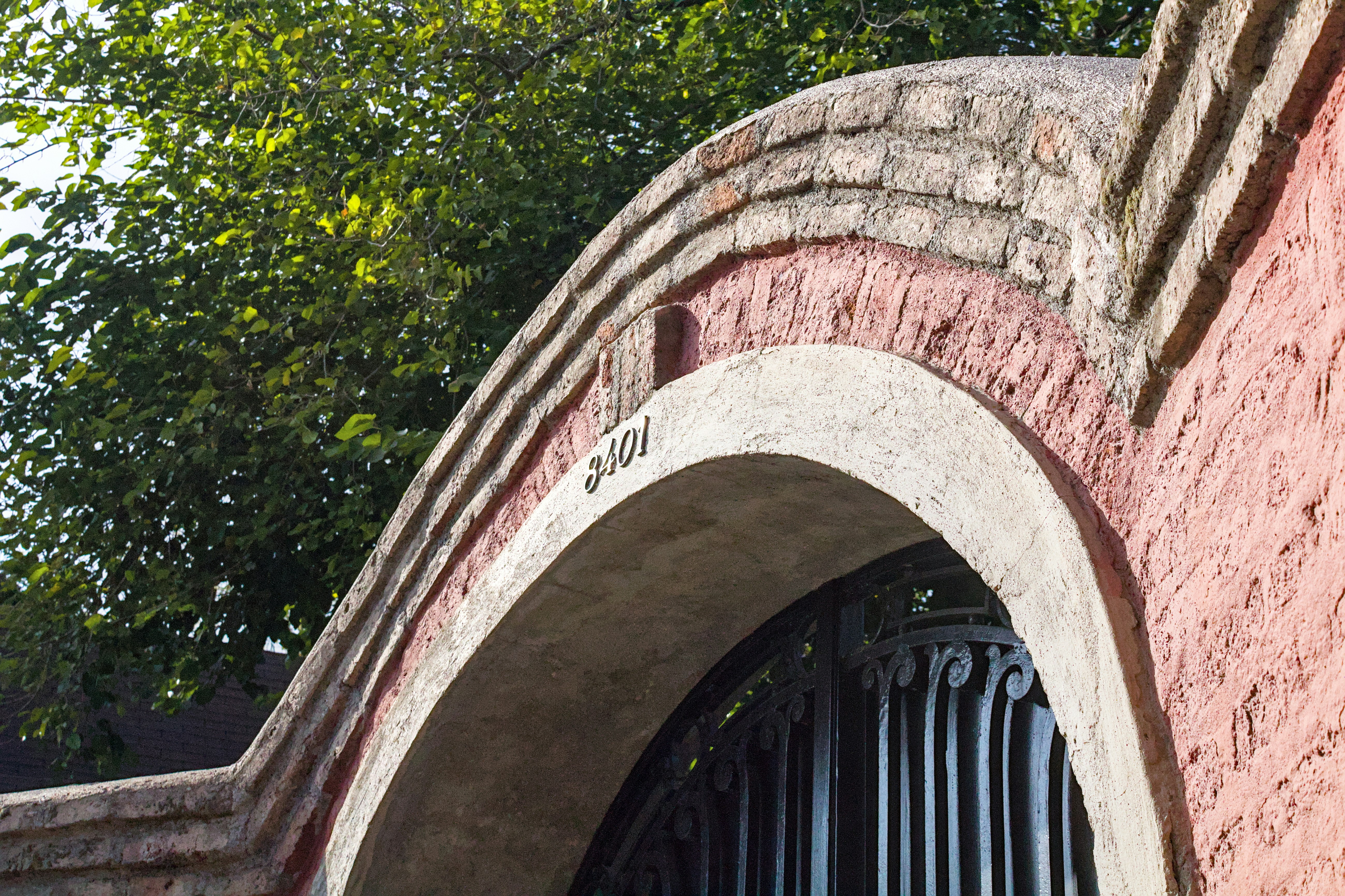 Archway Curve: A Brick Gate Framed by Green Canopy