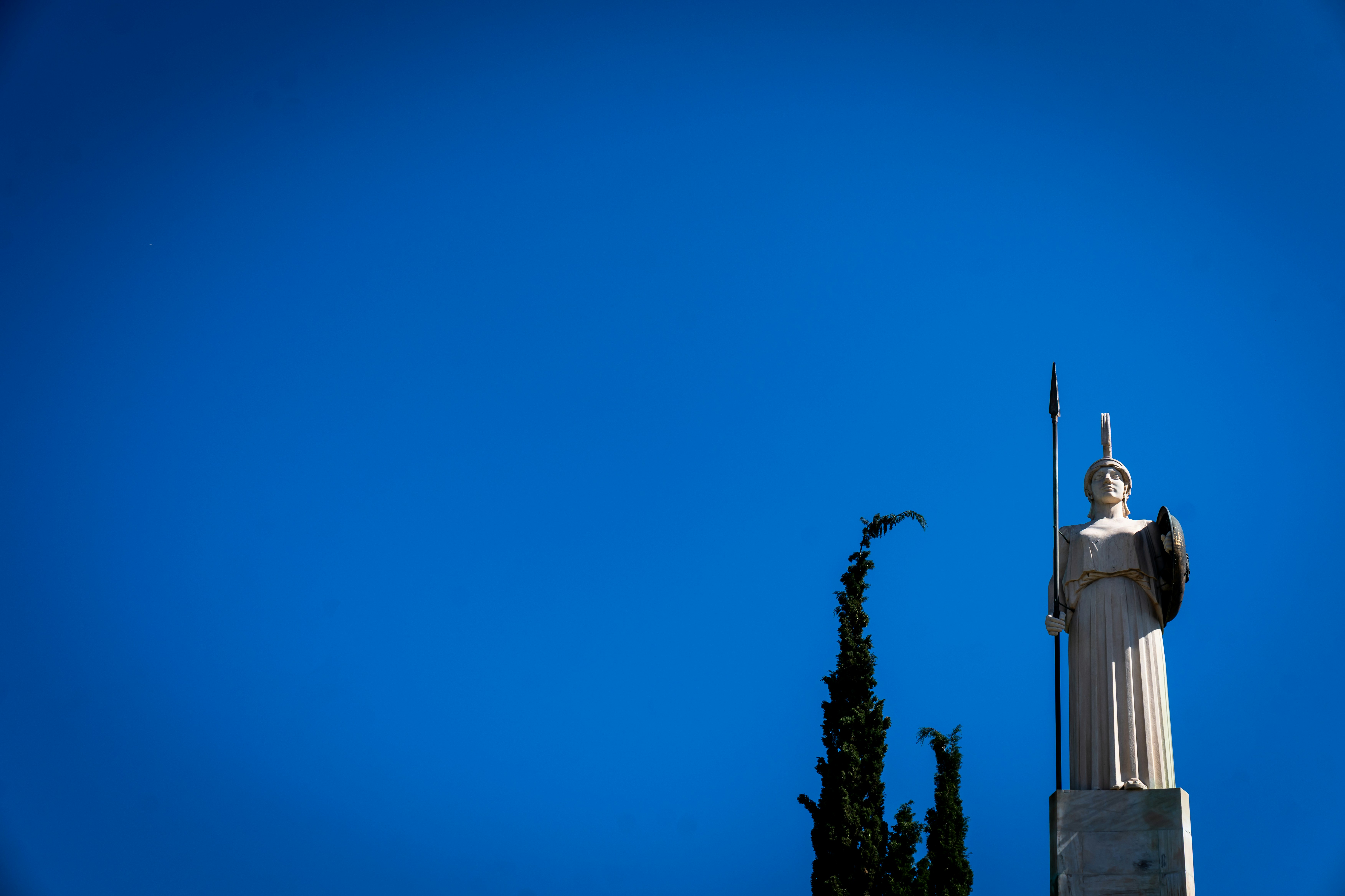 Temple Guardian on the Edge: A solitary statue against a vast cerulean sky