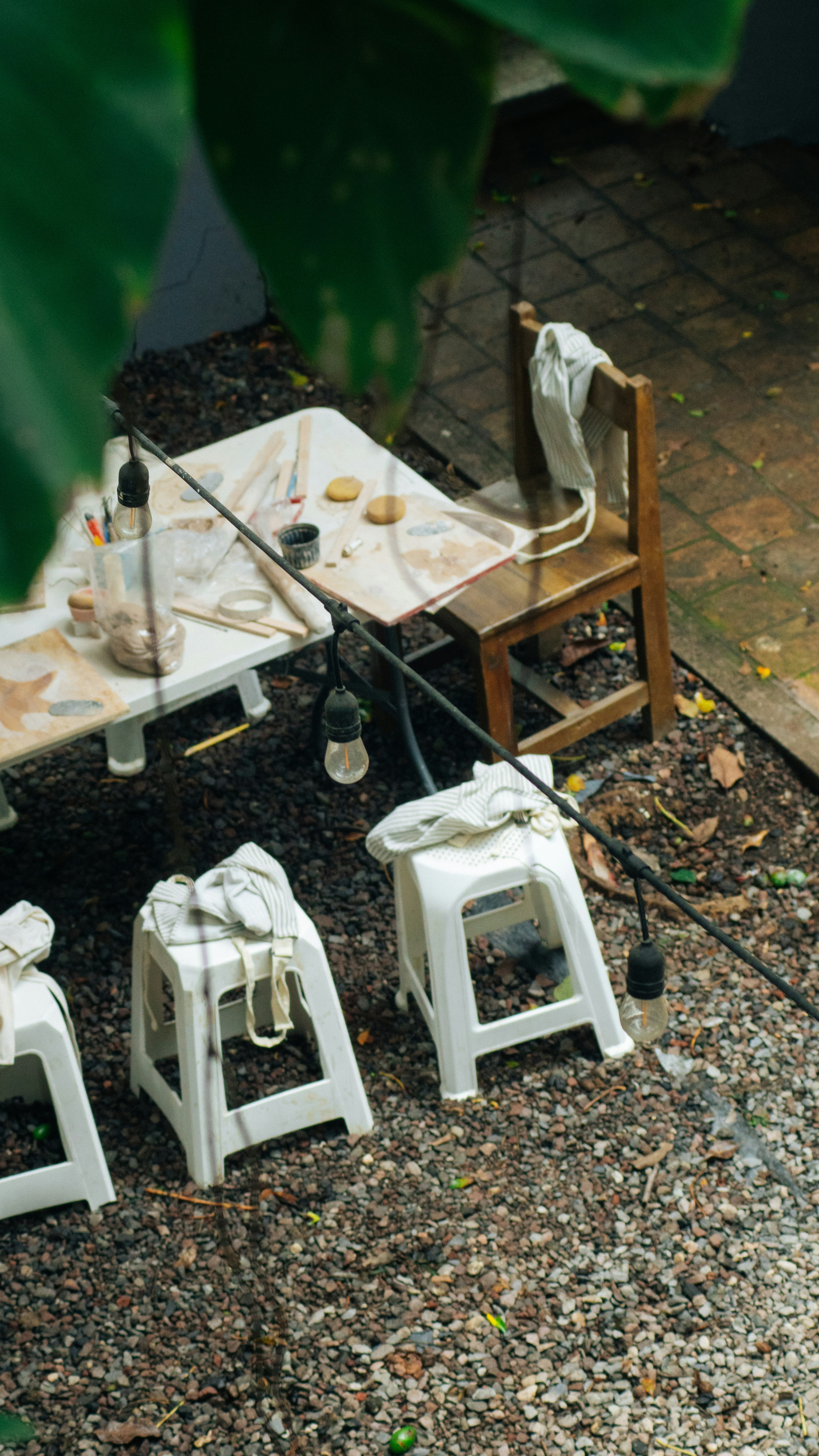 Overcast Atelier: A makeshift art corner under leafy shelter
