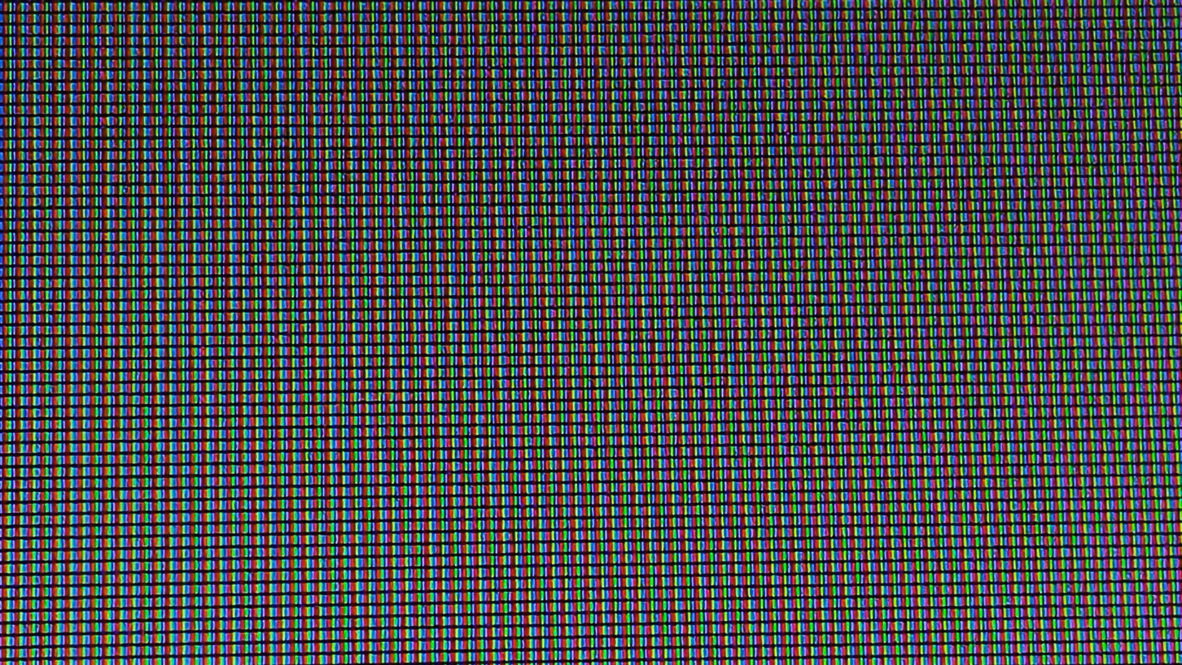 A high-detail close-up photography capturing the vibrant red, green, and blue subpixels of a digital display. This abstract geometric pattern creates a retro-futuristic, tech-inspired texture, perfect for UI/UX backgrounds, cyberpunk designs, and technology-themed layouts with ample vertical space for text.