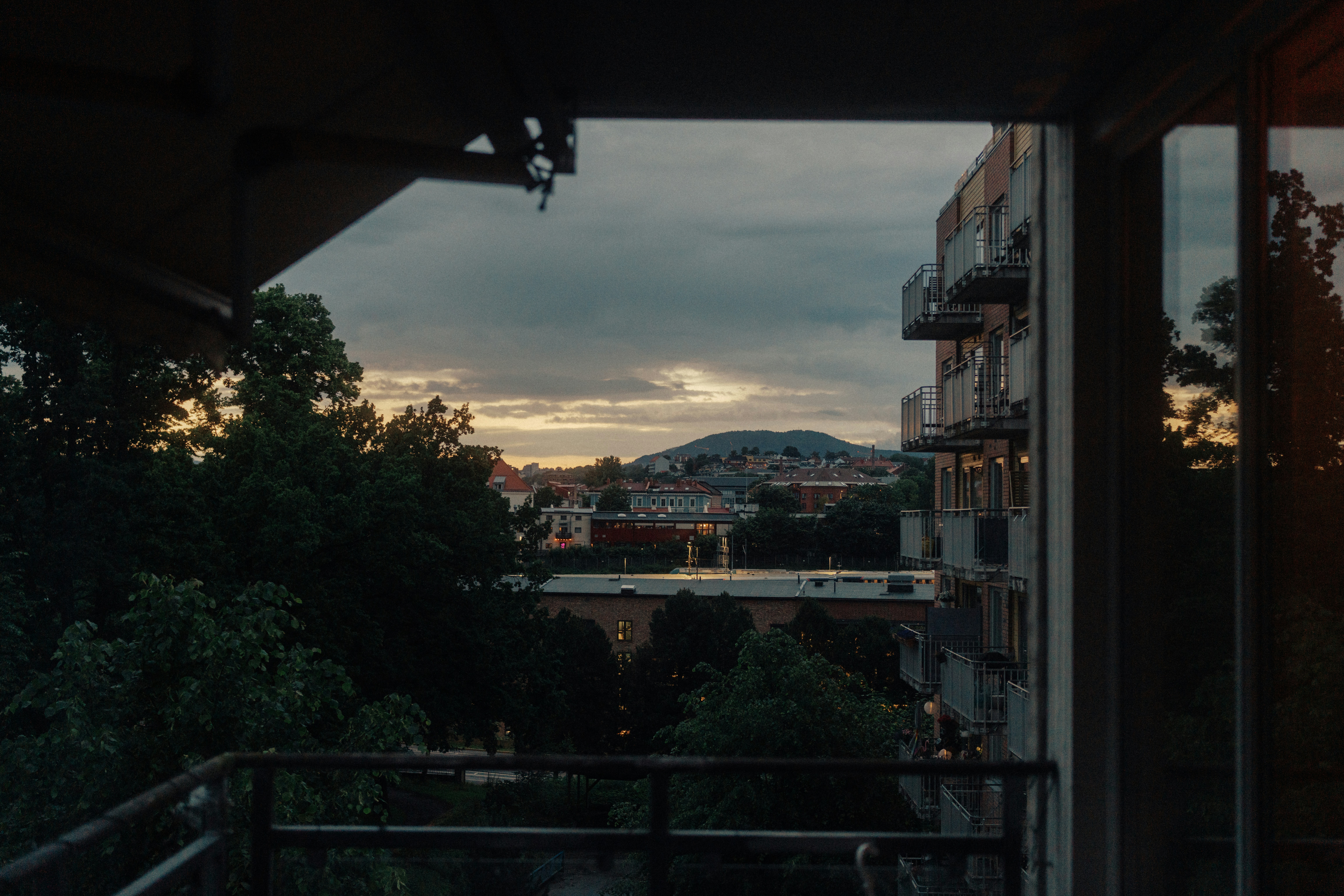 Distant cityscape at dusk from a shadowed balcony