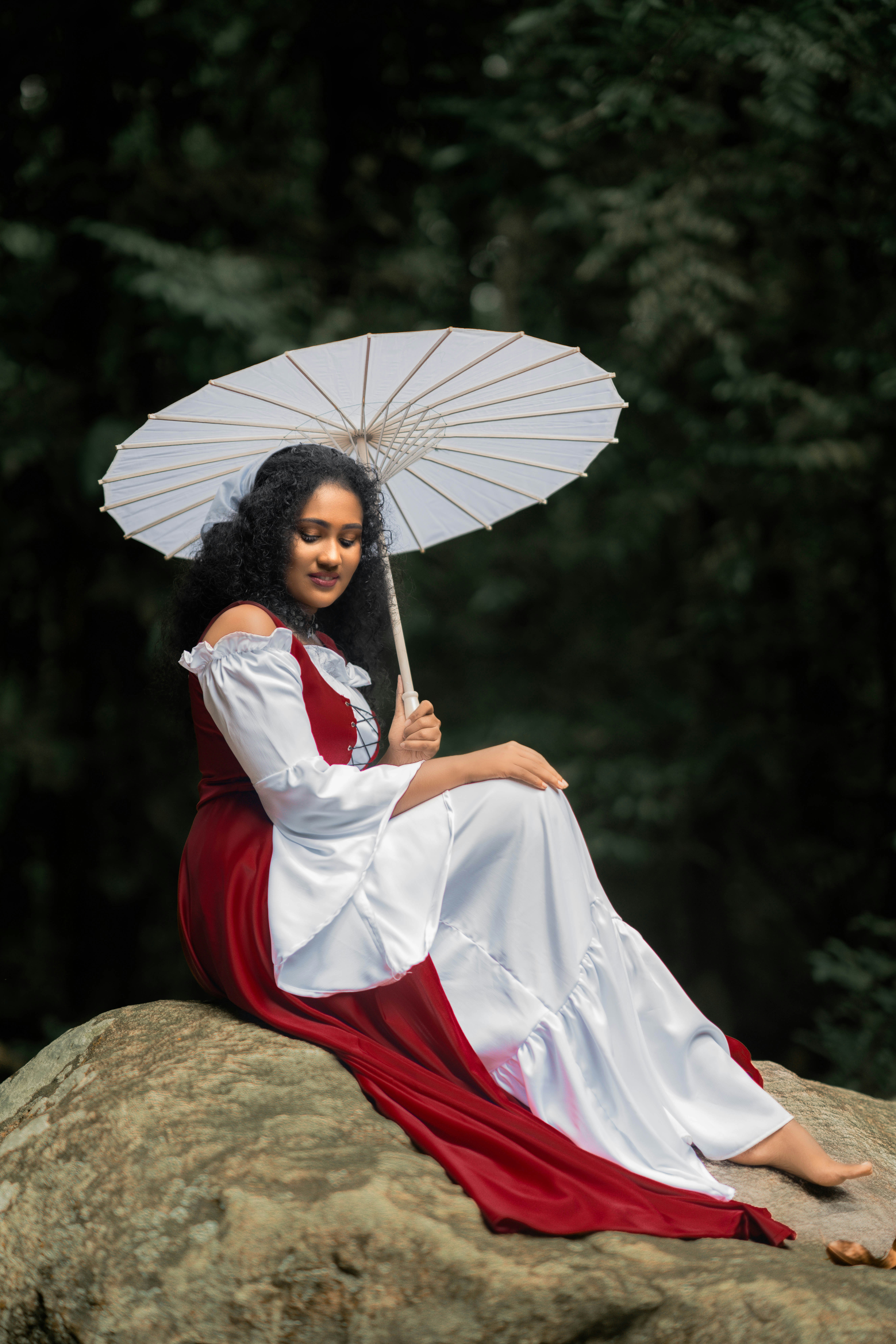 Elegance on Stone: A Vintage Red-Cloaked Portrait under a White Parasol