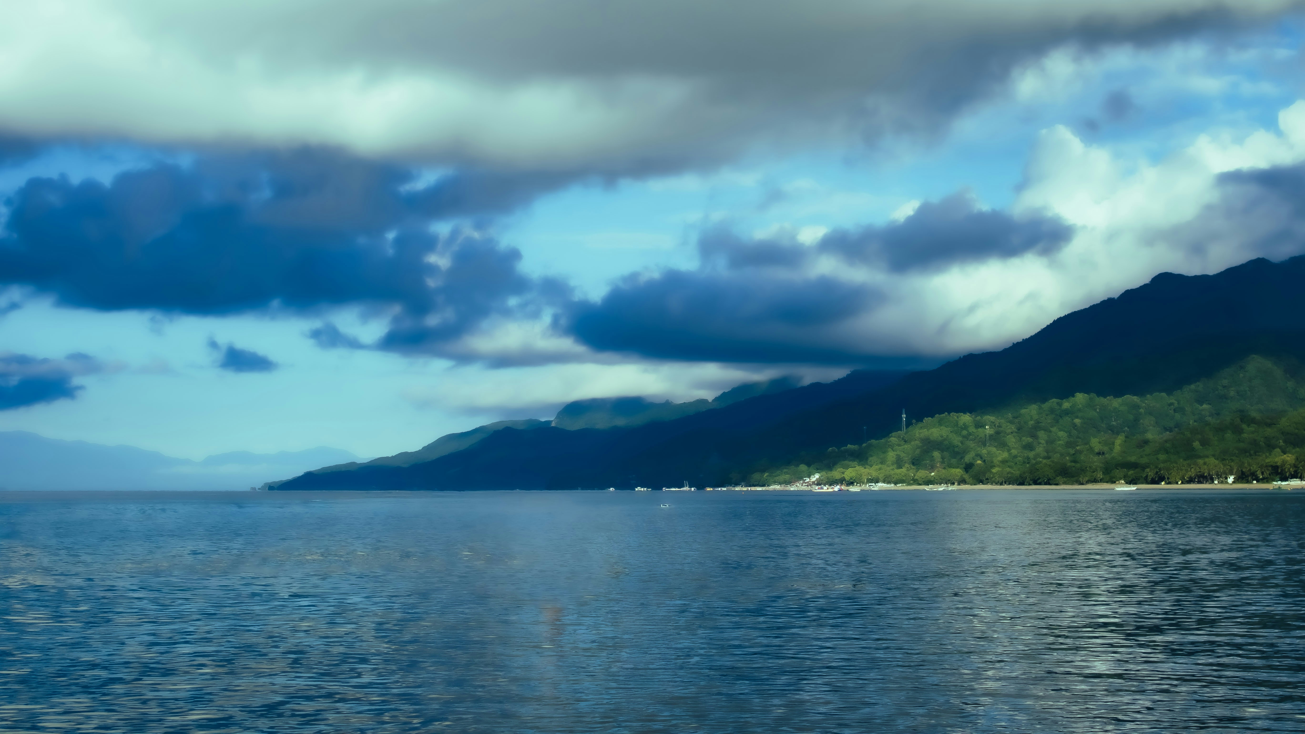 Azure Horizon: A Quiet Sea Meeting the Mountain Crest