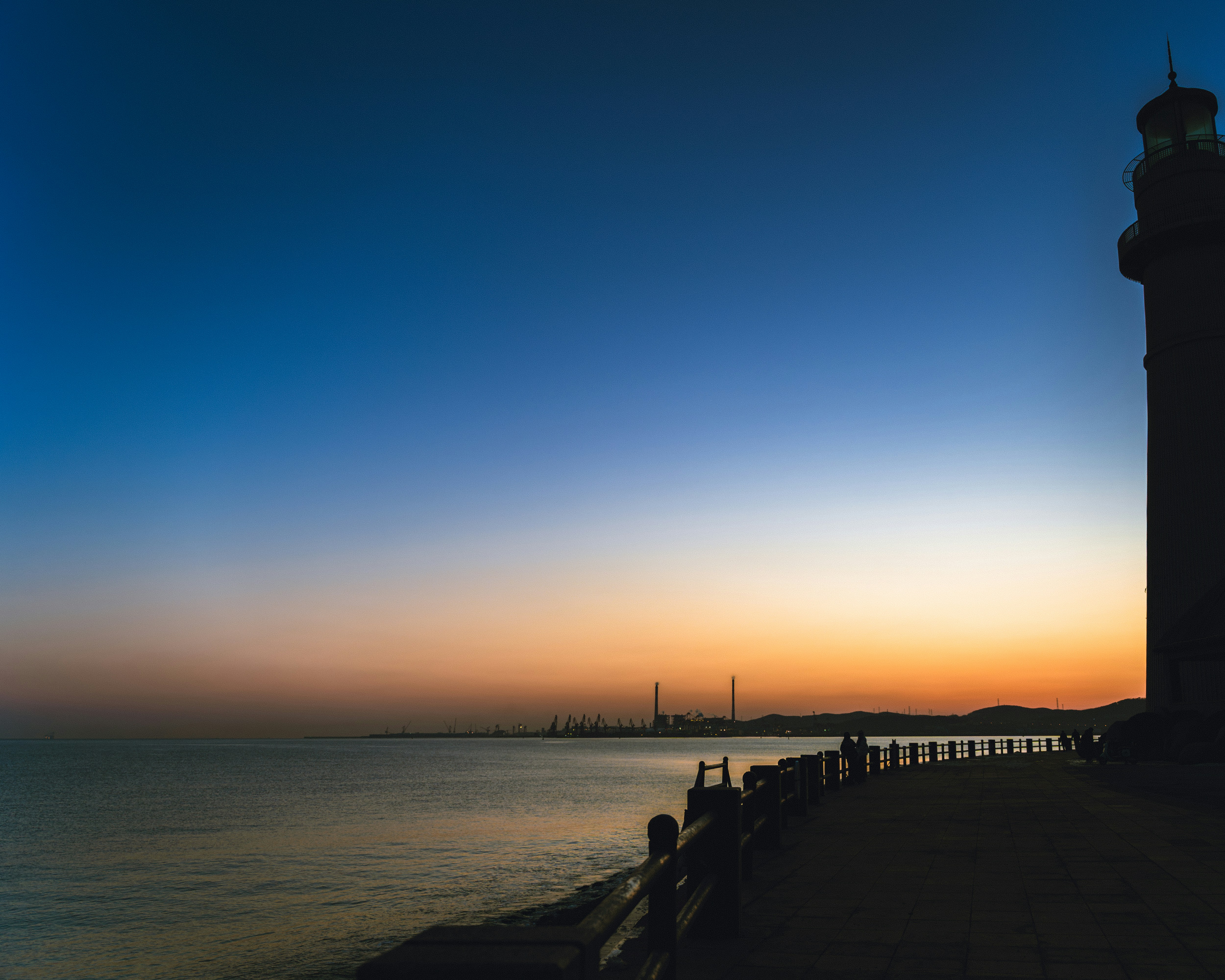 Dawn on the Pier: Calm Horizon by the Lighthouse