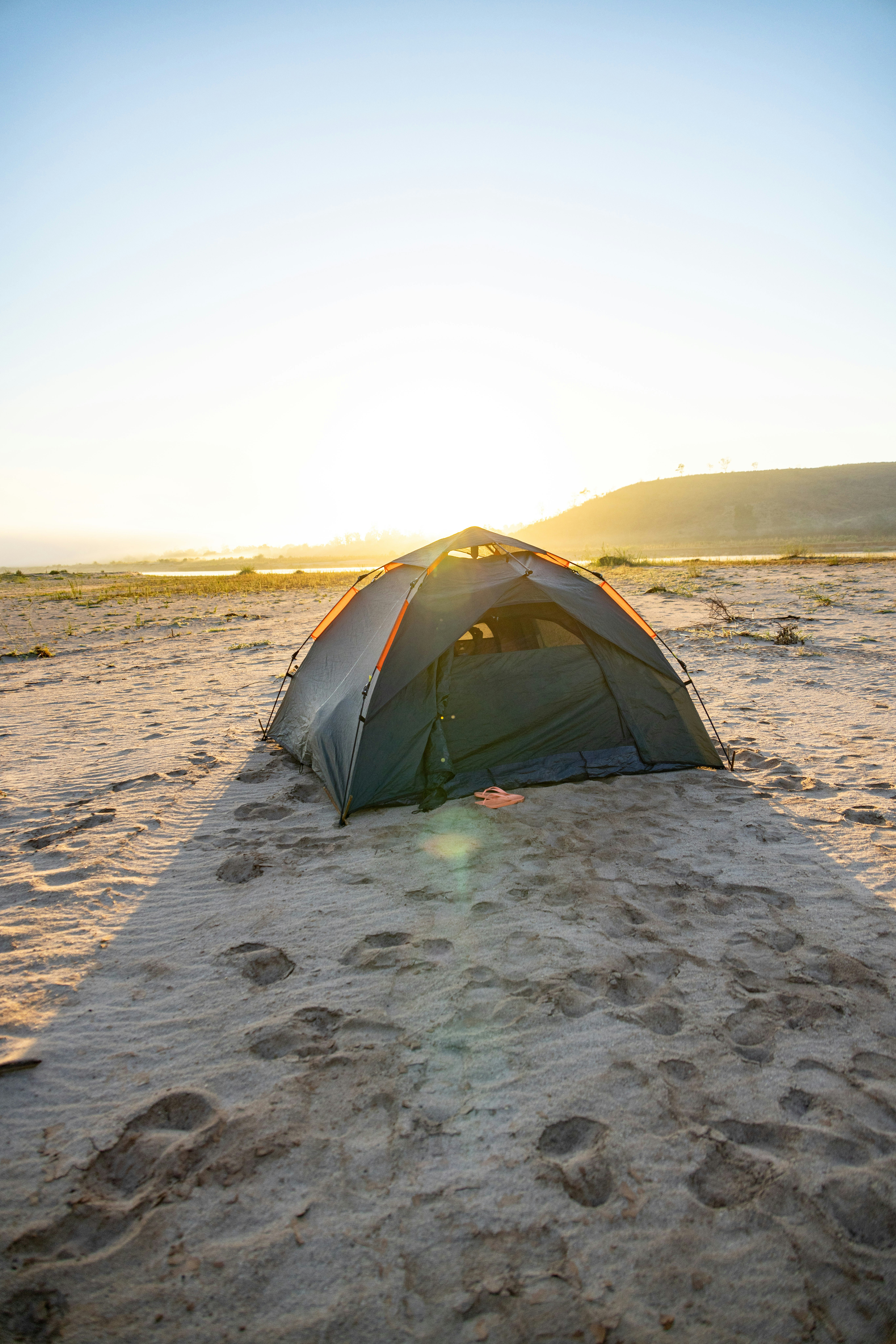 Desert Dawn: A Lone Tent Amidst the Expanding Shoreline Light