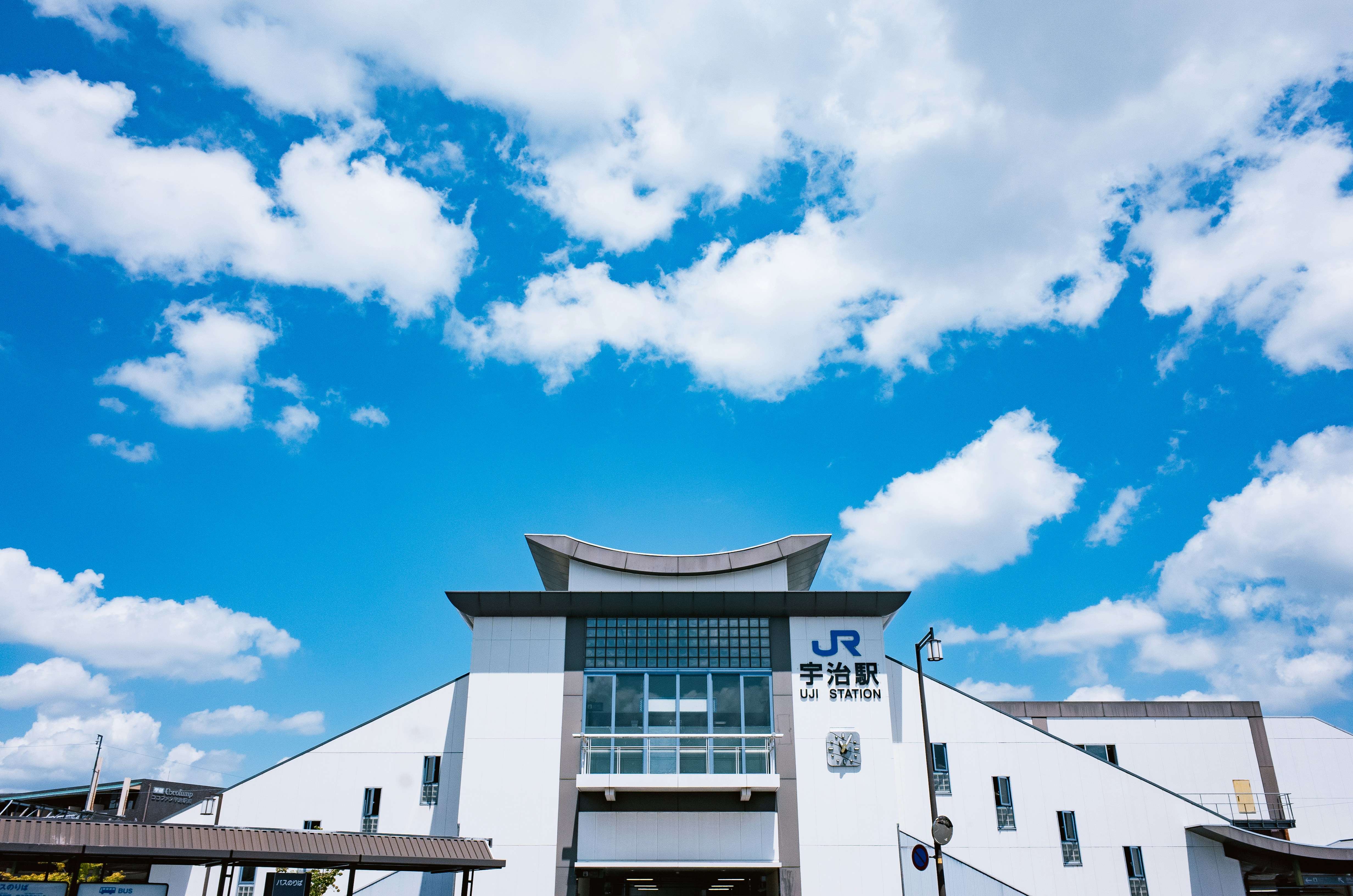 A modern white train station under a bright blue sky.