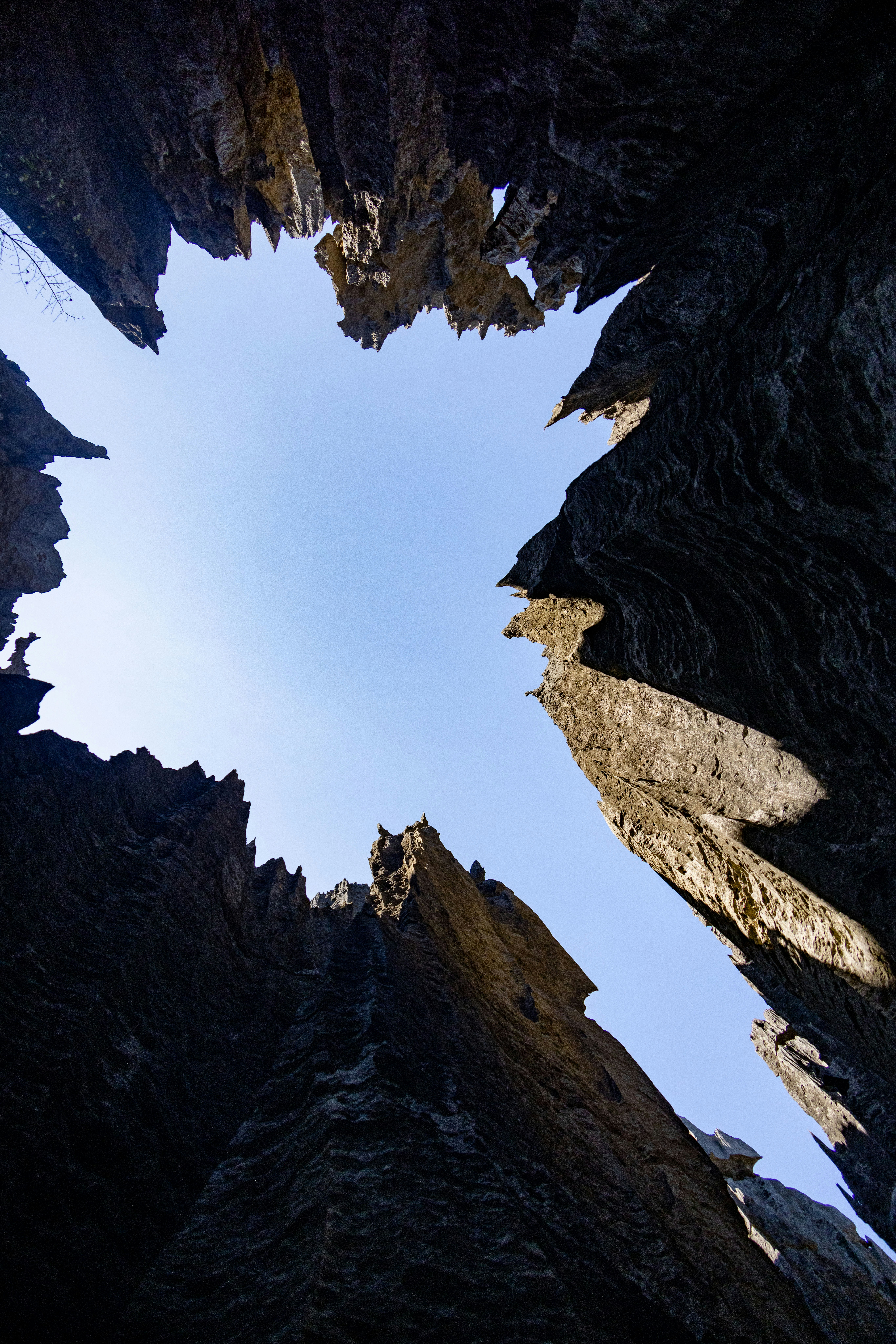 Skyward Rift: Sunlit Canyon Peaks Encircling a Blue Opening