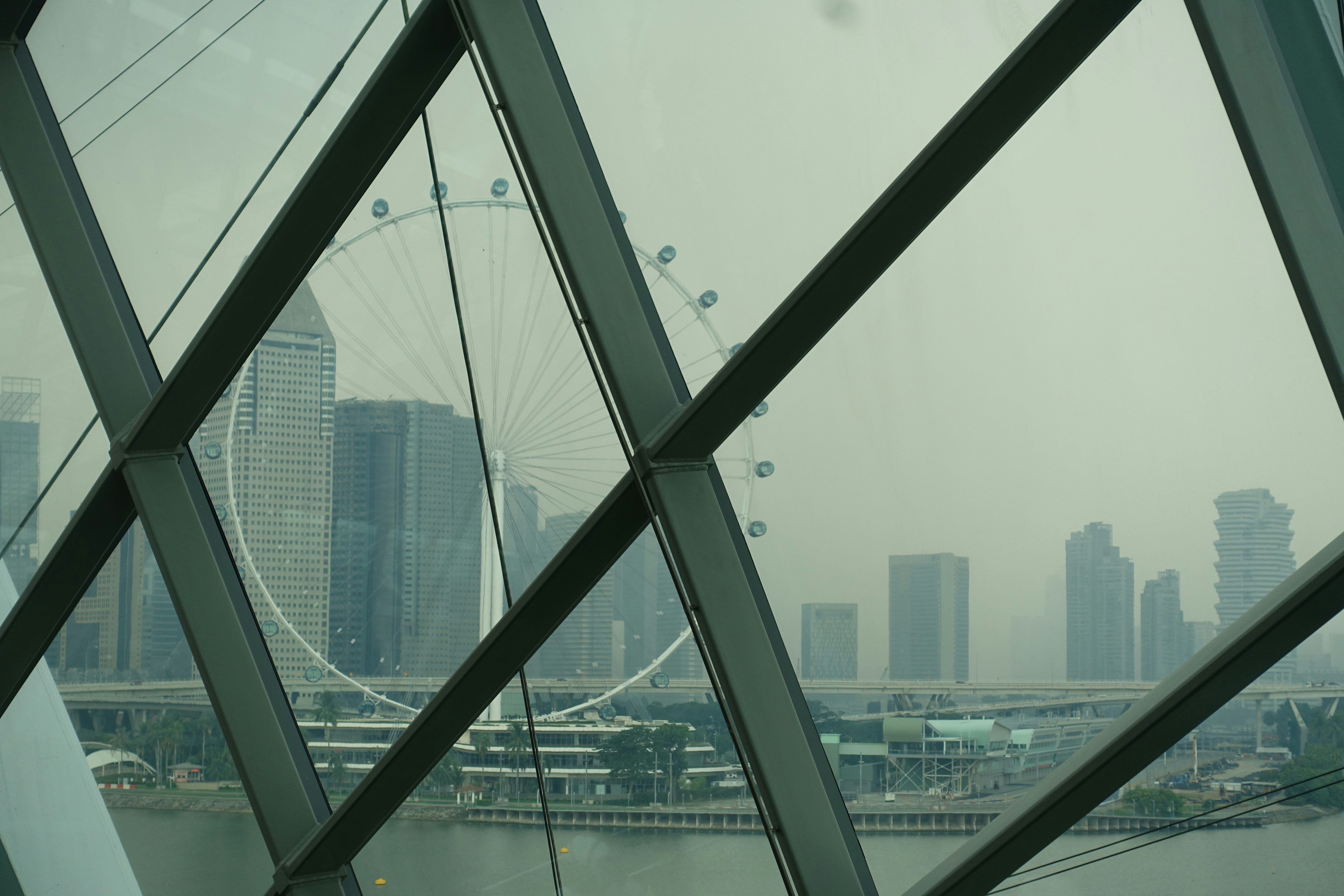 Windowed Skyline: Cityscape Framed by Steel Beams and a Giant Ferris Wheel