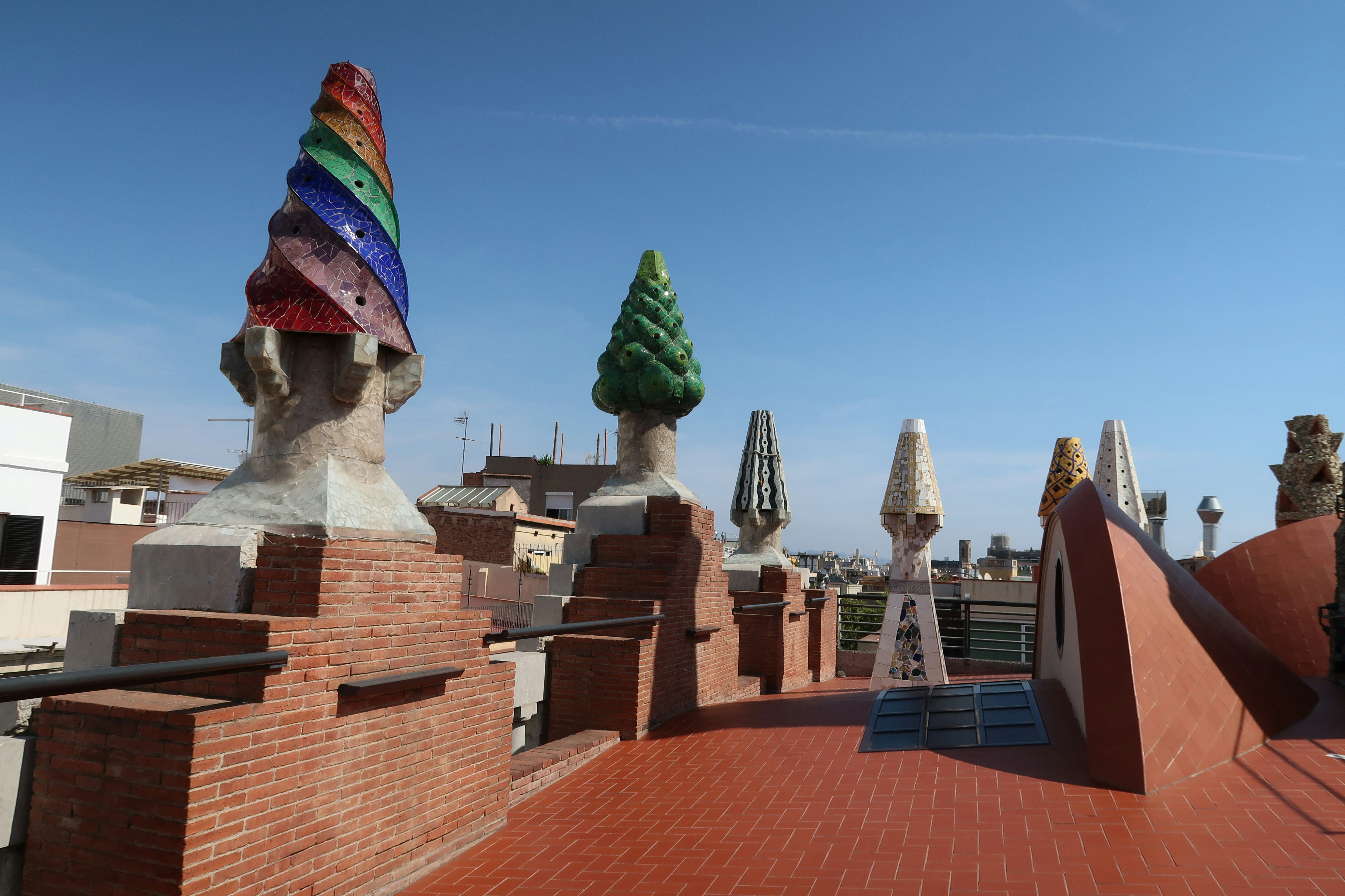 Rooftop Chimneys: Rainbow Helix and Verdant Spire Against a Clear Blue