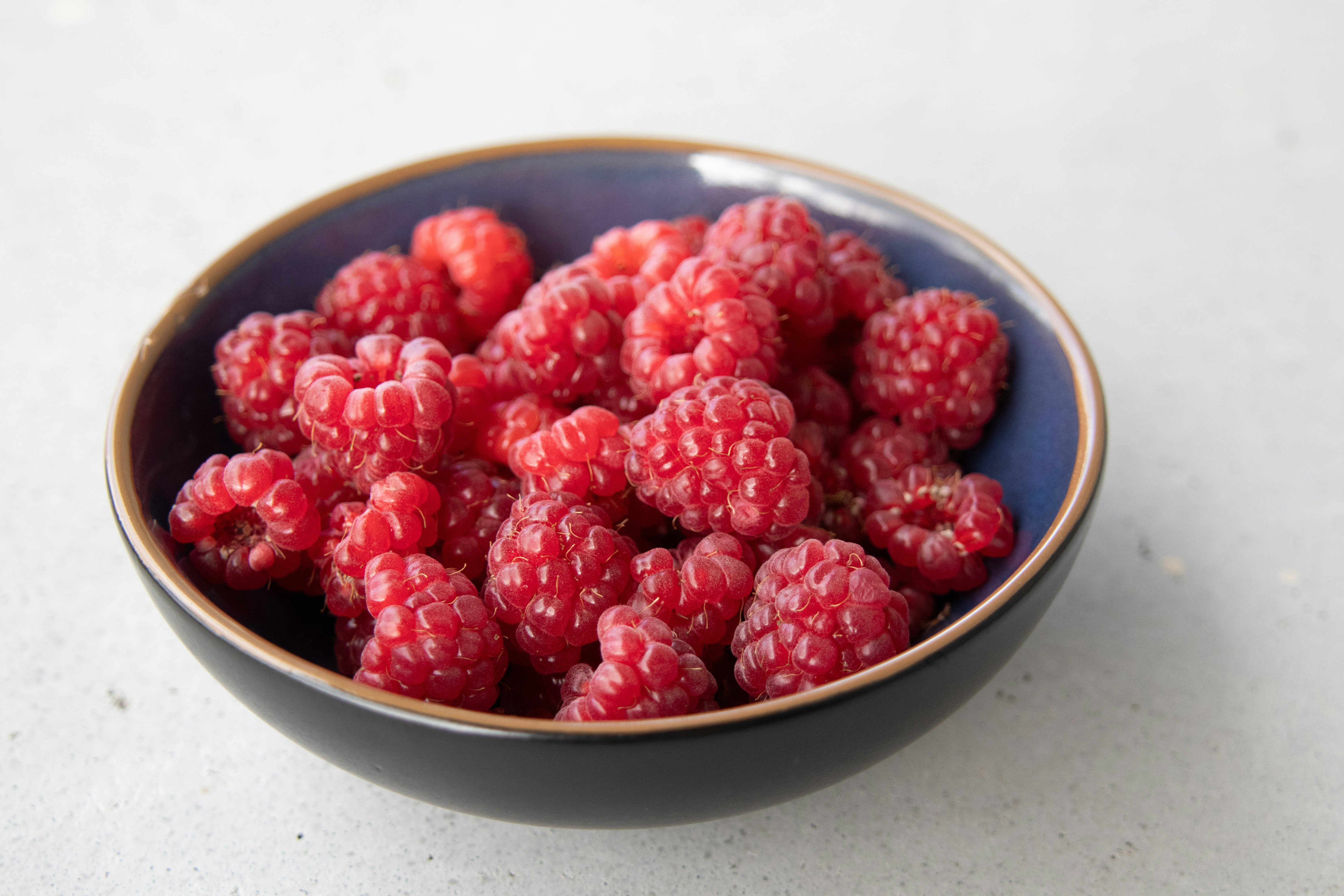 Rosy Raspberry Bowl: A Precise Burst of Color on Light Stone