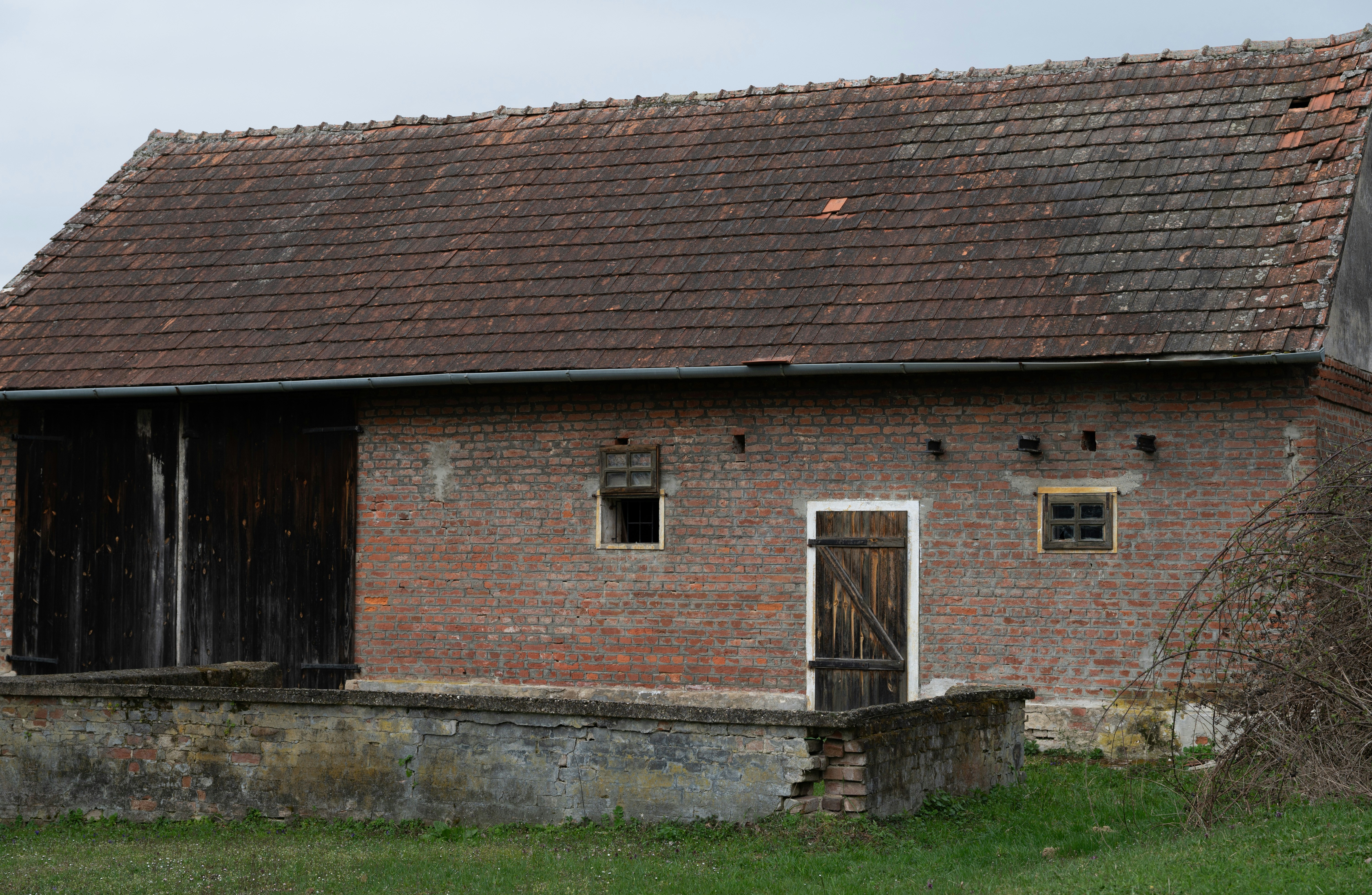 Old Brick Barn with Weathered Roof and Worn Doorway