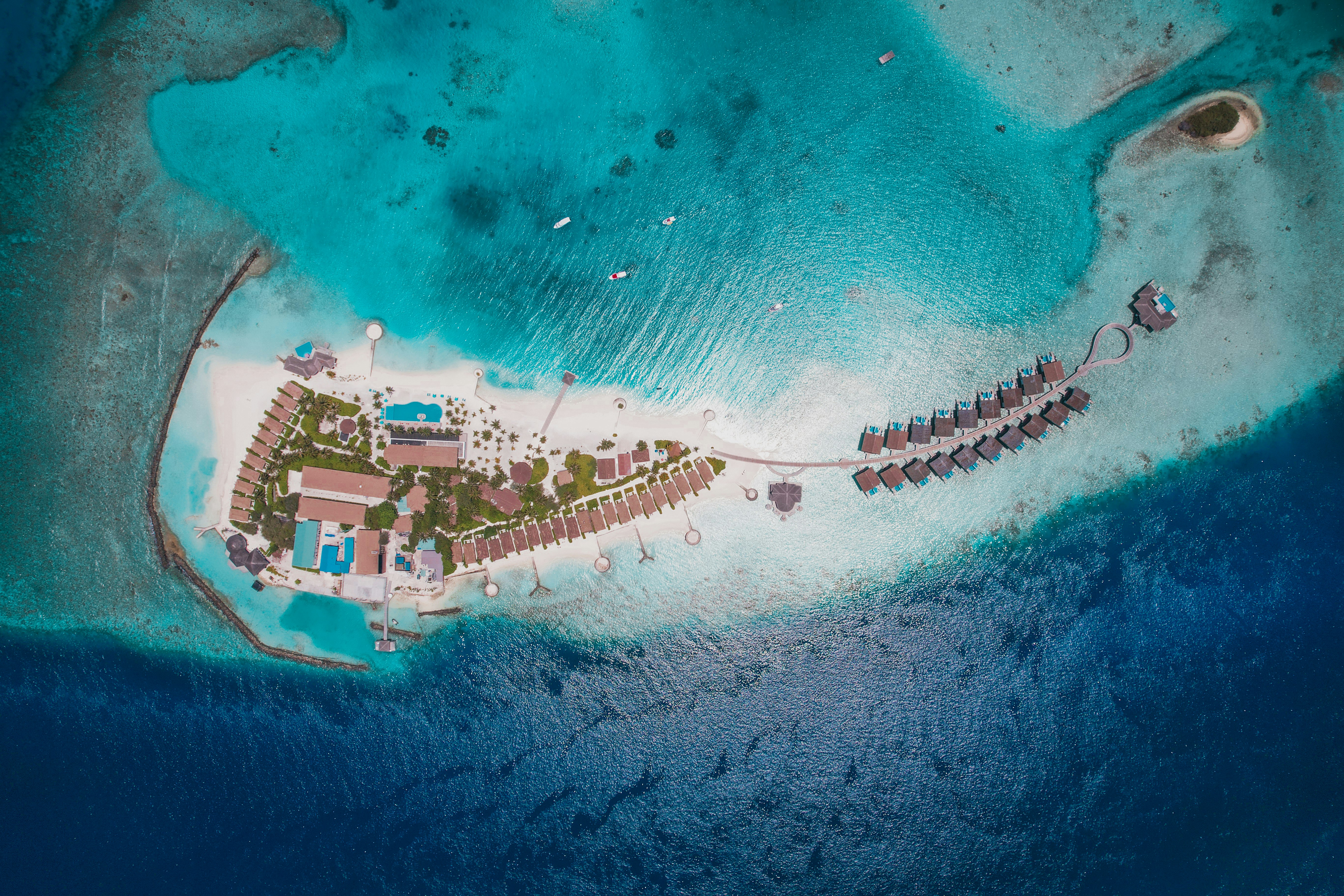 Aerial view of a tropical island resort and turquoise ocean.